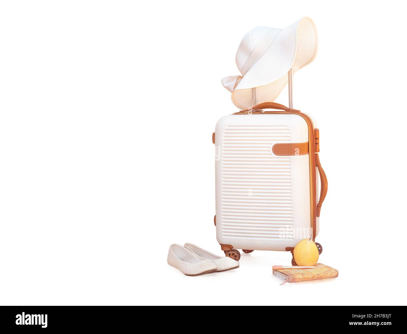Beige suitcase with hat, shoes, pear and book isolated on white ...