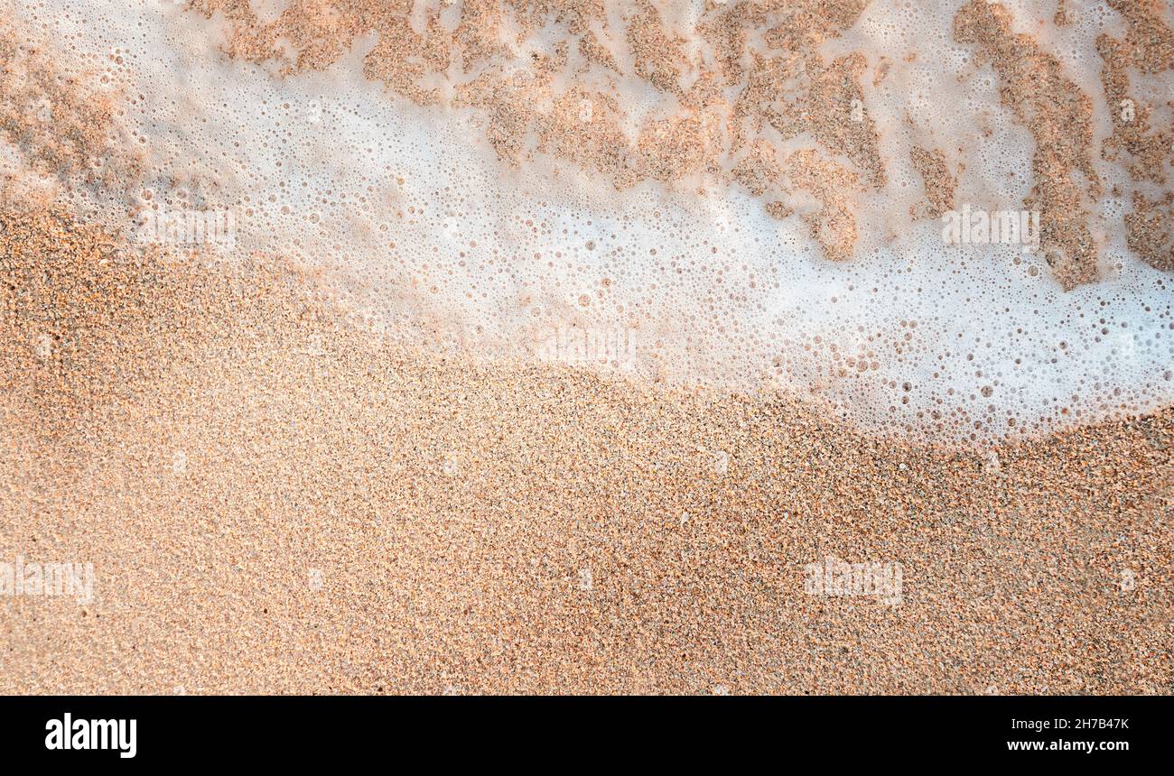 Sand water background. Wave with foam on the sand Stock Photo - Alamy