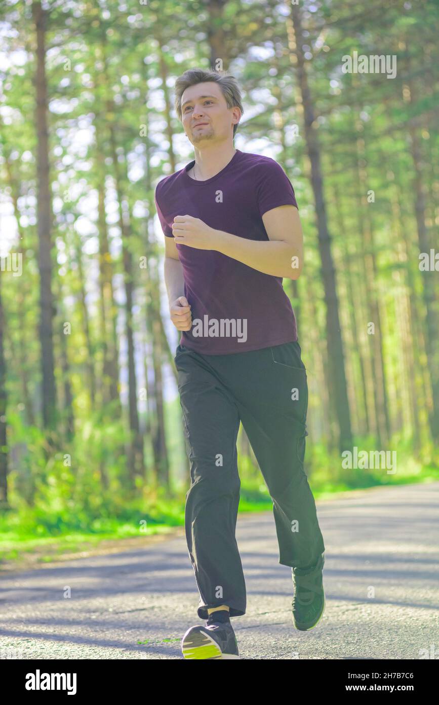 Running man jogging in city park at beautiful summer day. Sport fitness ...