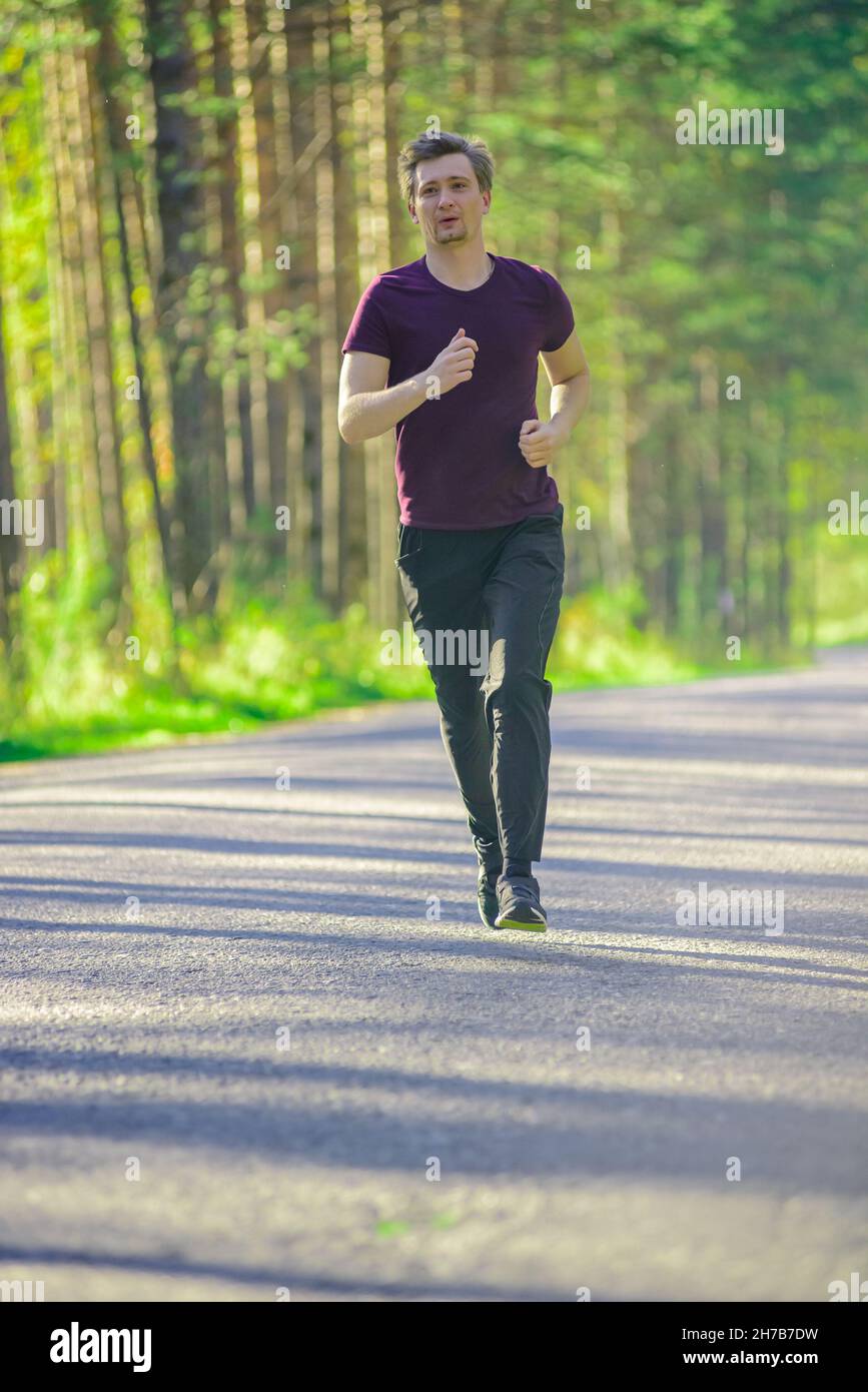 Running man jogging in city park at beautiful summer day. Sport fitness ...