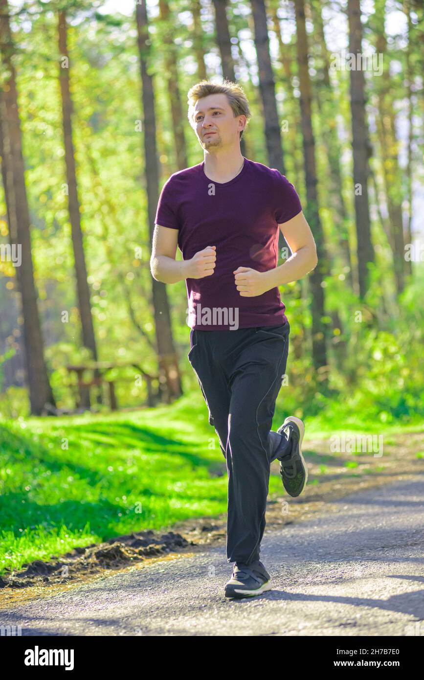 Running man jogging in city park at beautiful summer day. Sport fitness ...