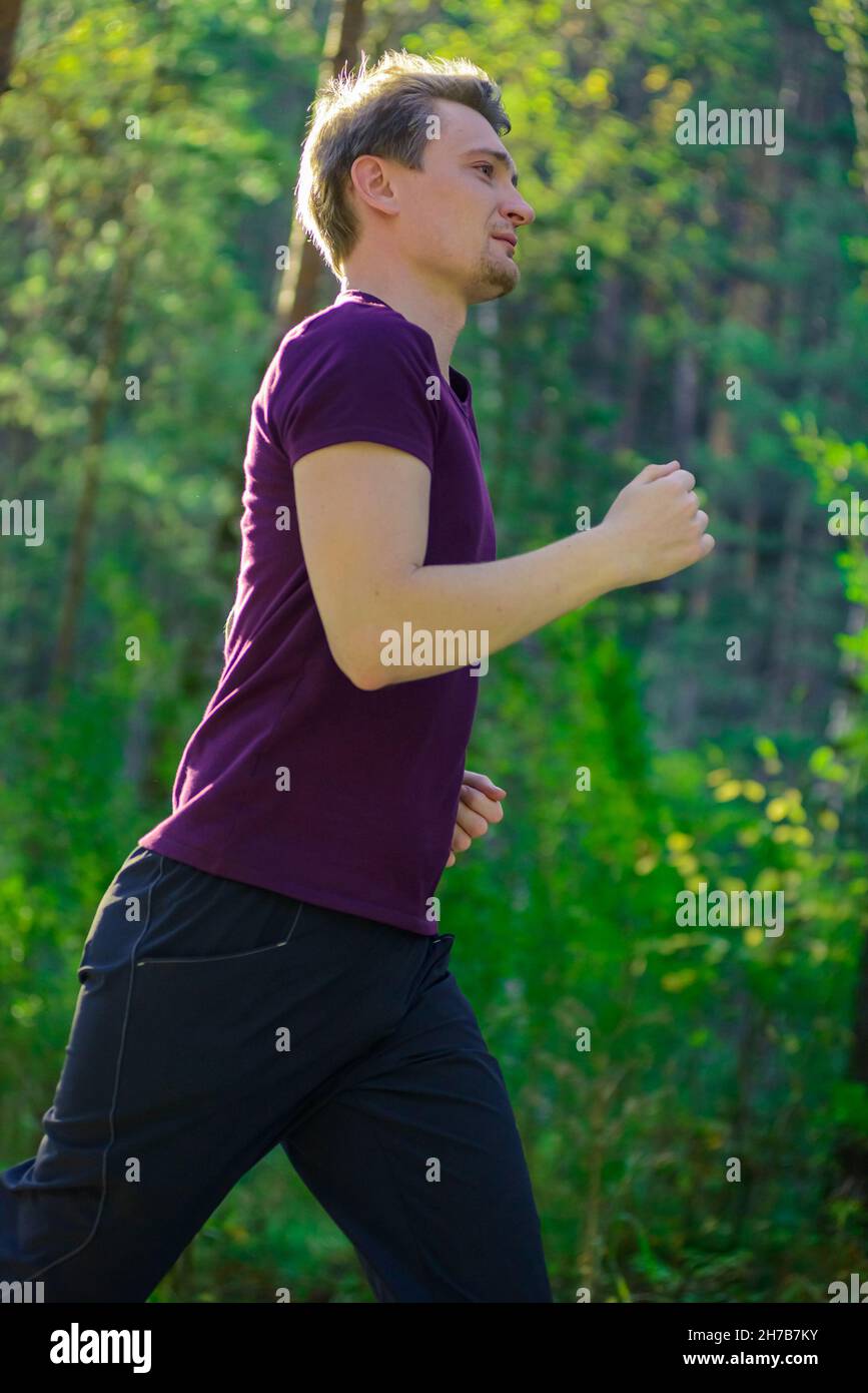 Running man jogging in city park at beautiful summer day. Sport fitness ...