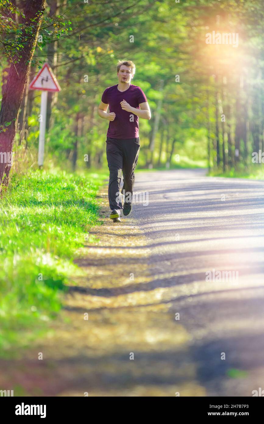 Running man jogging in city park at beautiful summer day. Sport fitness ...