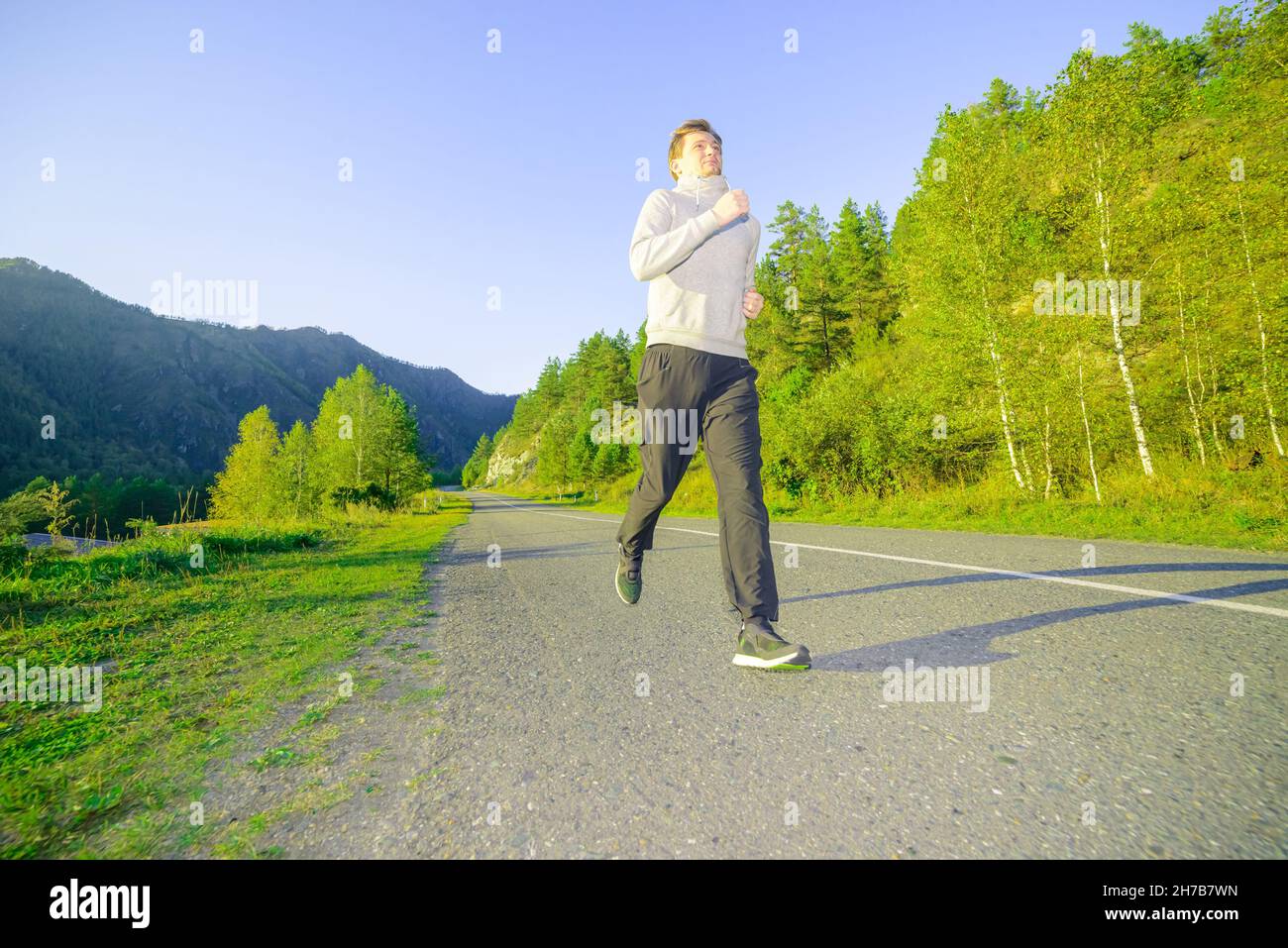 Running man jogging in city park at beautiful summer day. Sport fitness ...