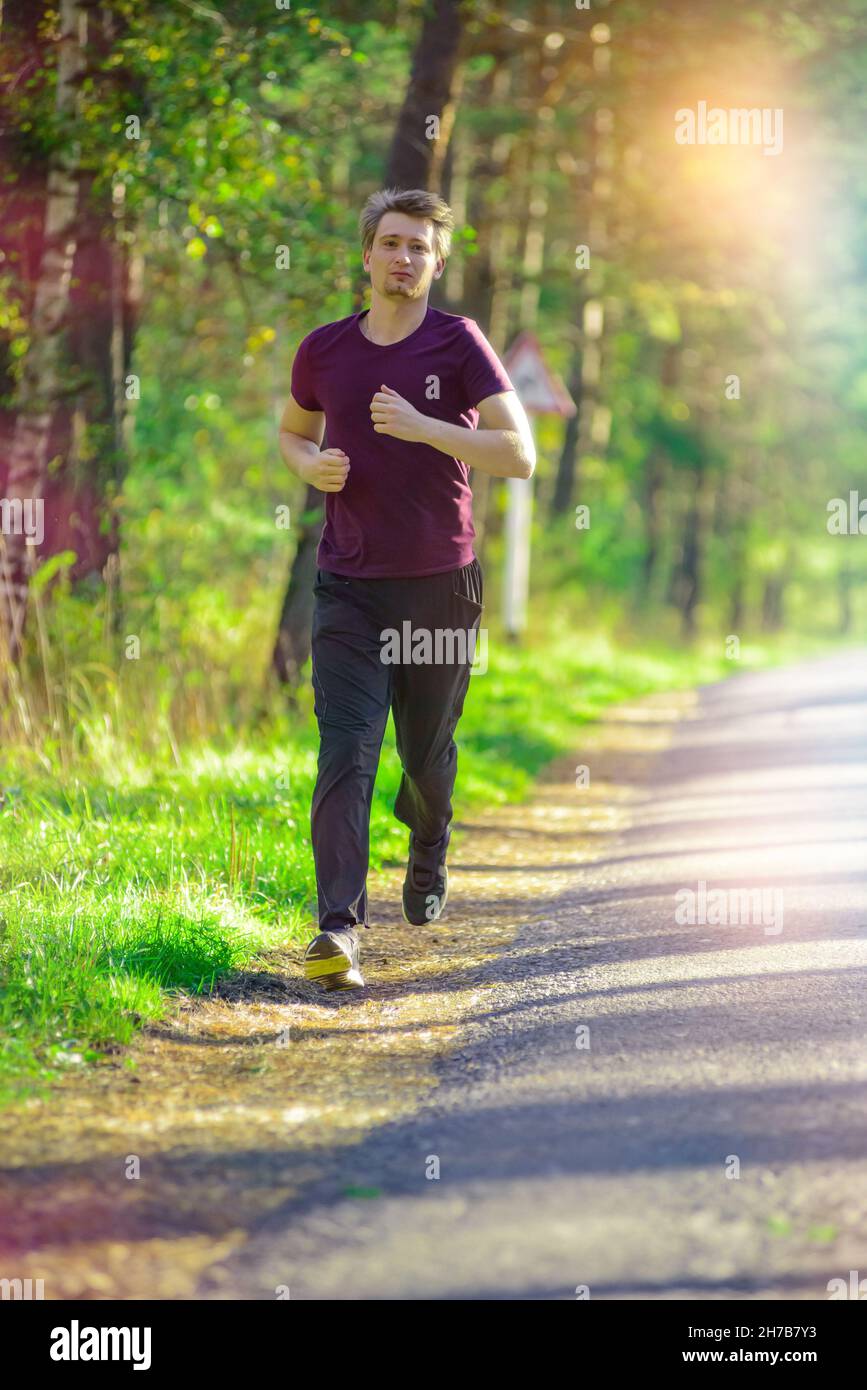 Running man jogging in city park at beautiful summer day. Sport fitness ...