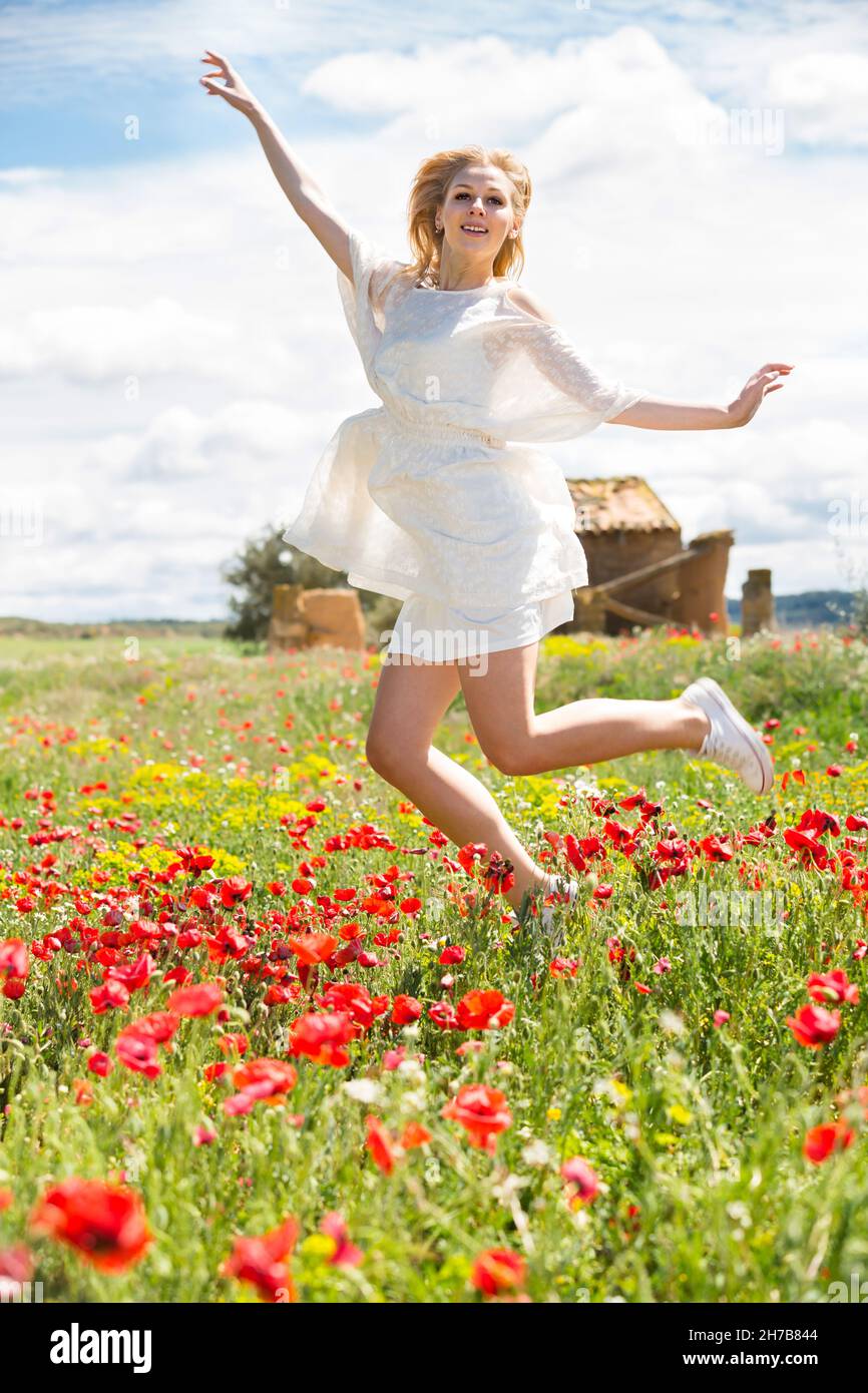 Girl jumping in field flowers hi-res stock photography and images - Alamy
