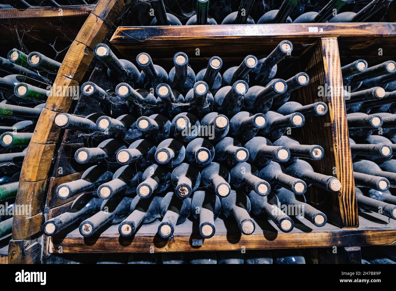 Shelves with aging alcohol glass bottles covered with dust at the wine ...