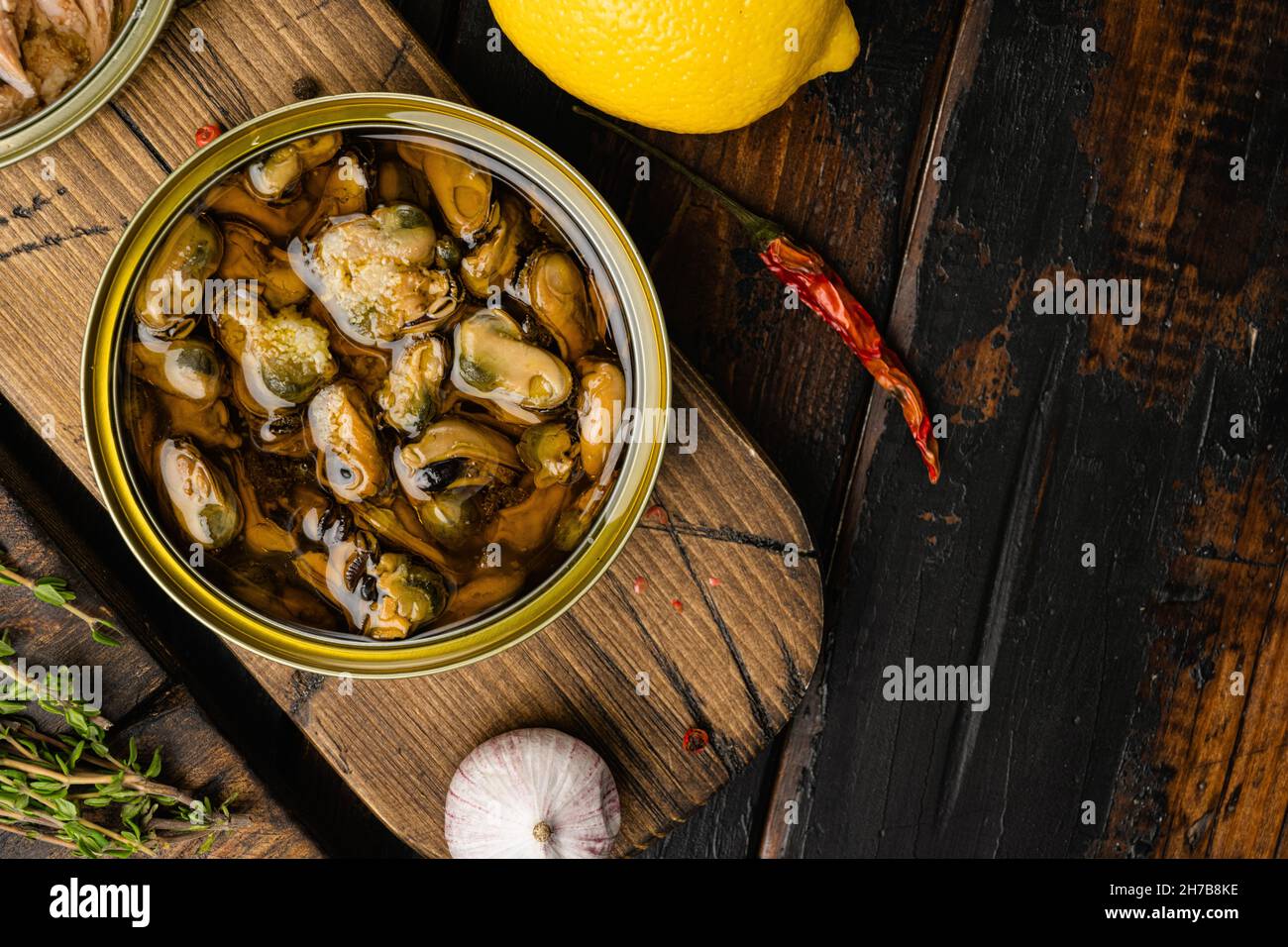 Marinated mussels in tin set, on old dark wooden table background, top ...