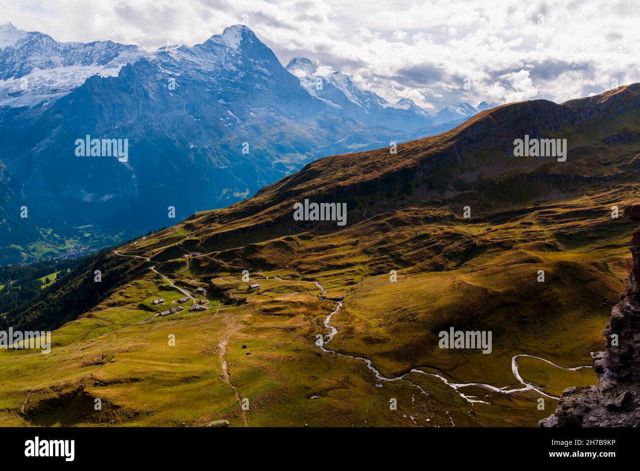 The Eiger in the Berner Oberland in the Swiss Alps, and a mountain stream reflects the sun from ...