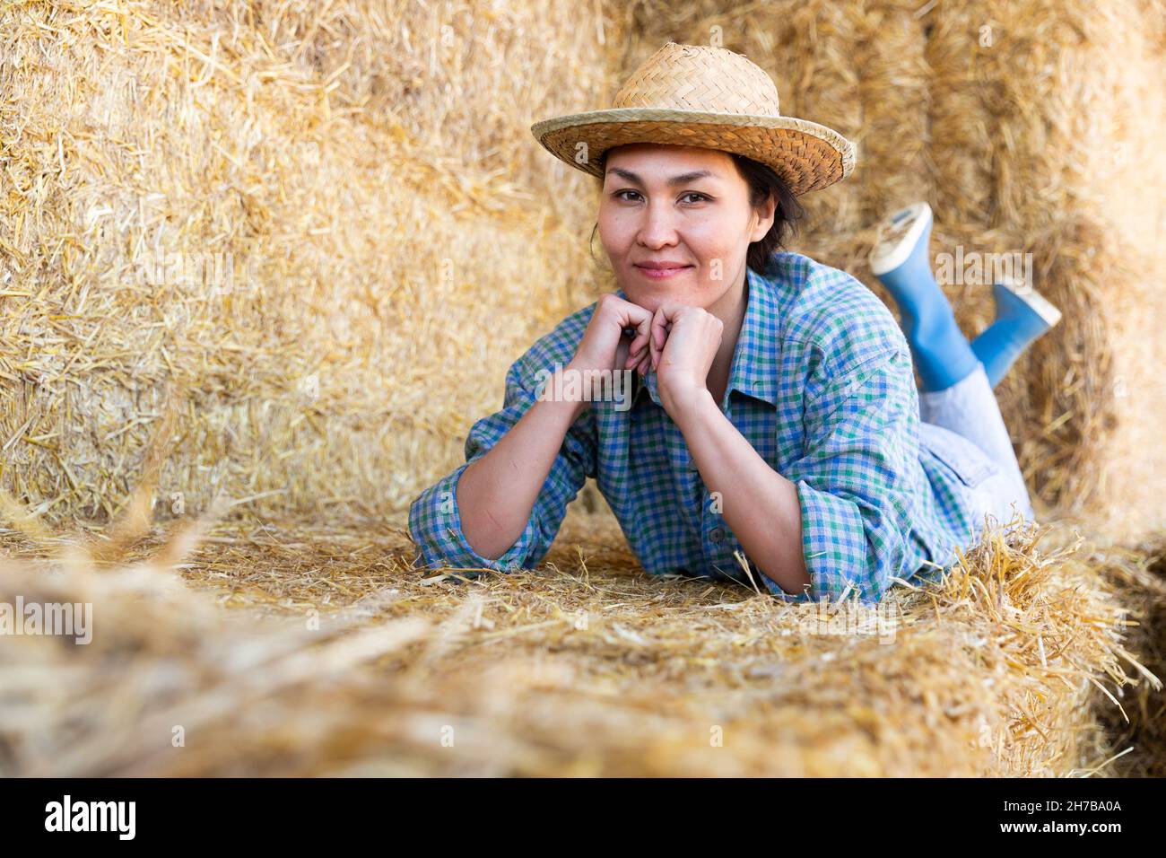 Cow farm owner posing in the barn against backdrop of hay bales Stock ...