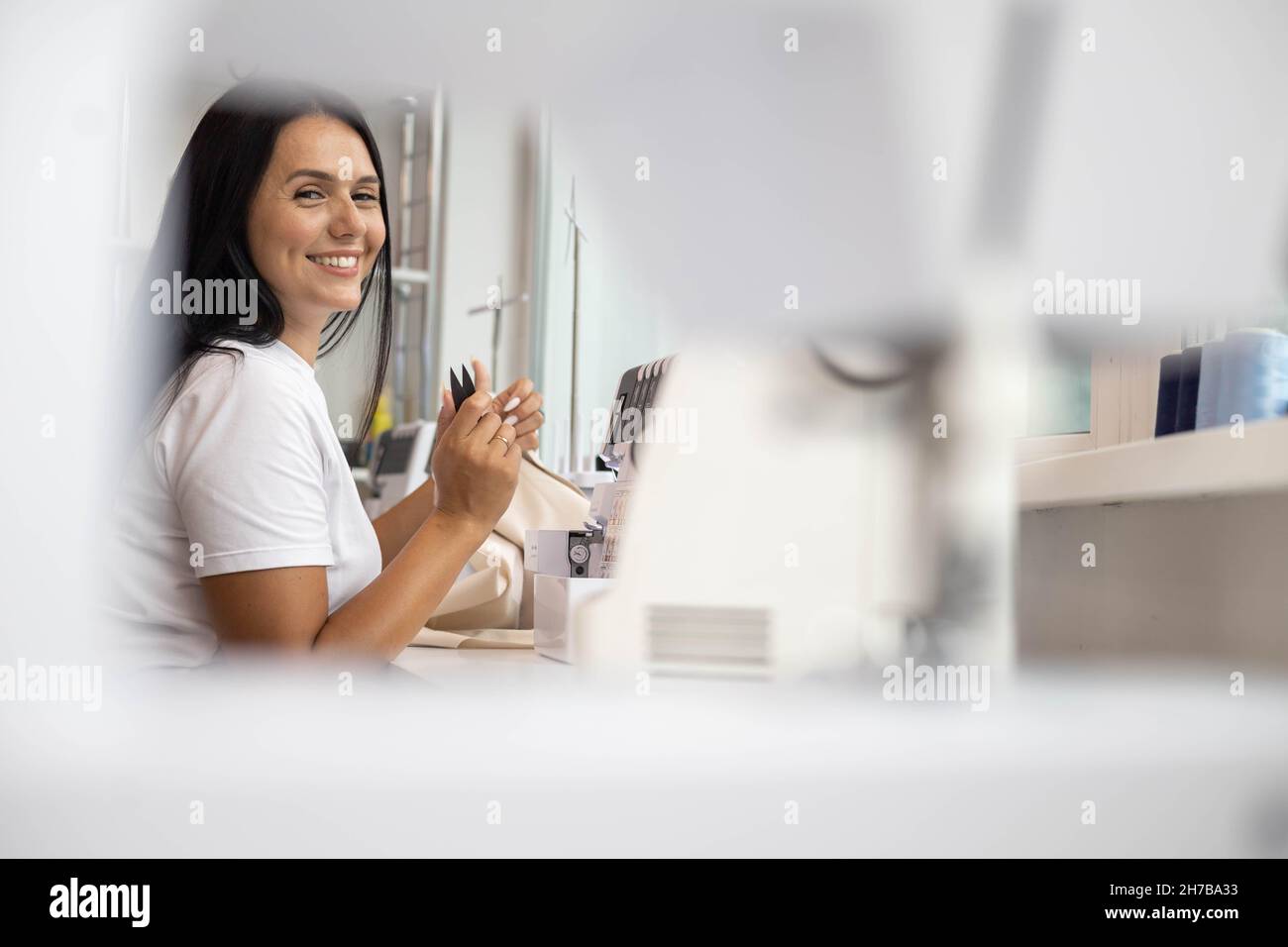 Professional female seamstress thread a needle use electric sewing ...