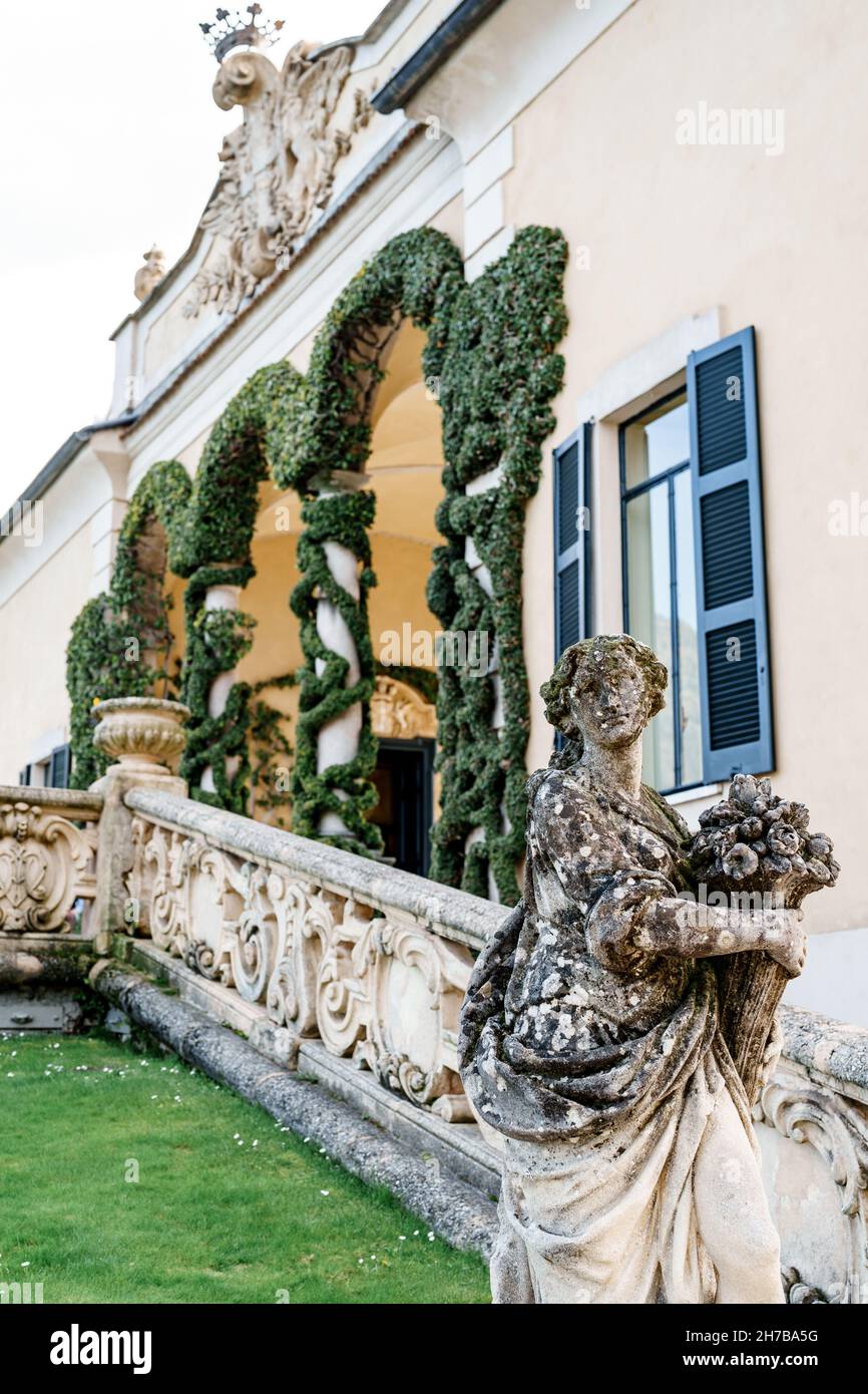 Statue near the balustrade of the lianas-twined arch of Villa ...