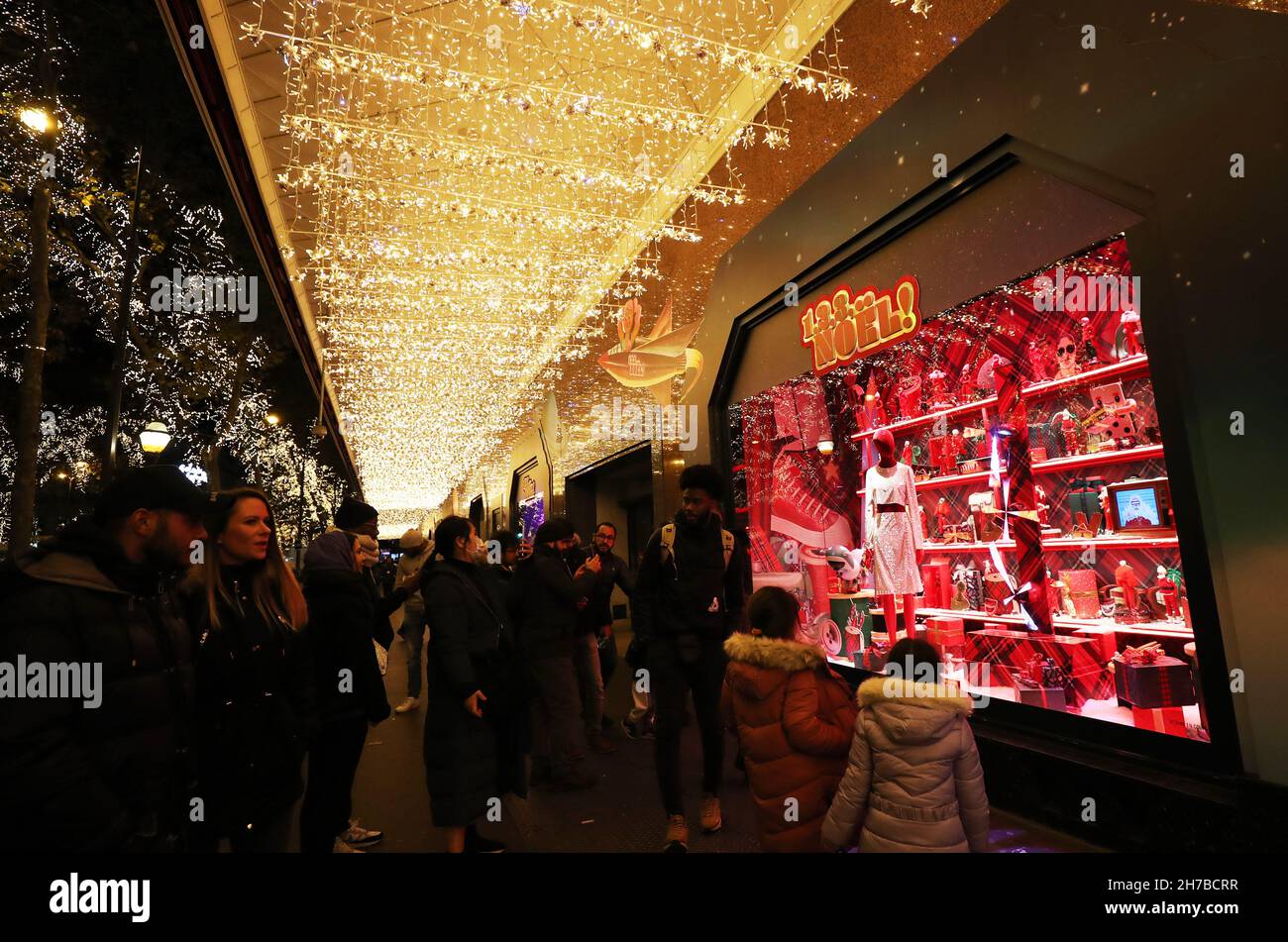 Paris, France. 21st Nov, 2021. Pedestrians look at the Christmas window ...
