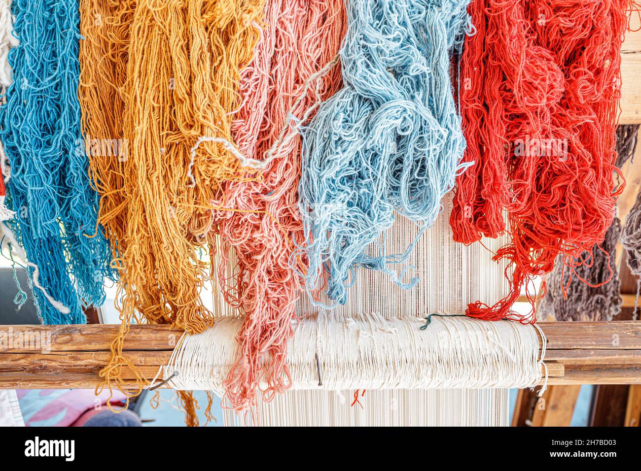 a spinning machine or a loom with colorful bright threads made of wool ...