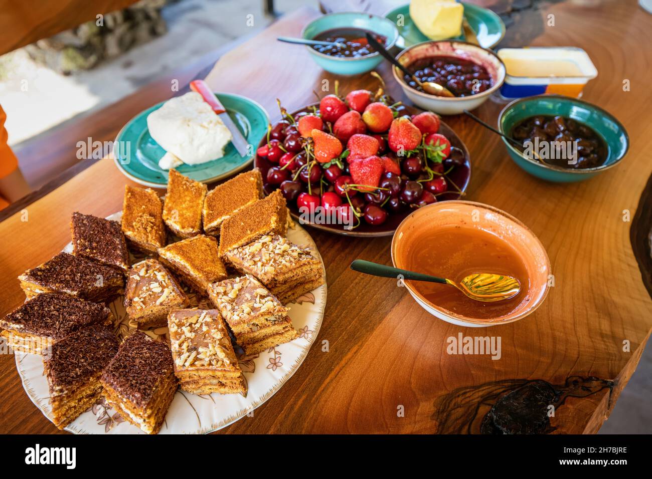 A lot of sweet foods on the table - cakes, honey and fruits - contain ...