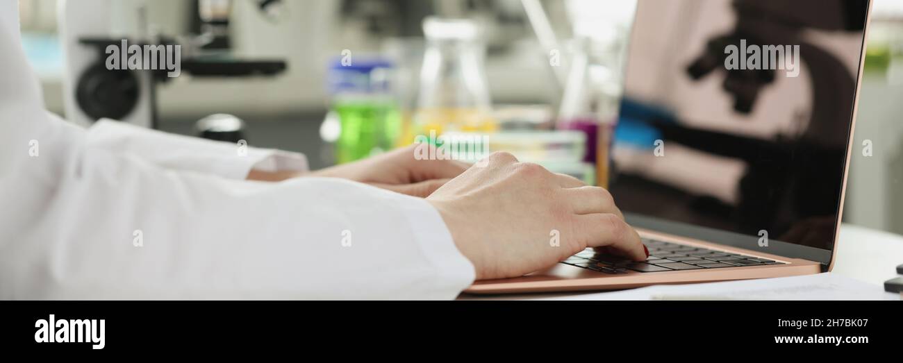 Scientist or student using laptop computer and microscope. online ...