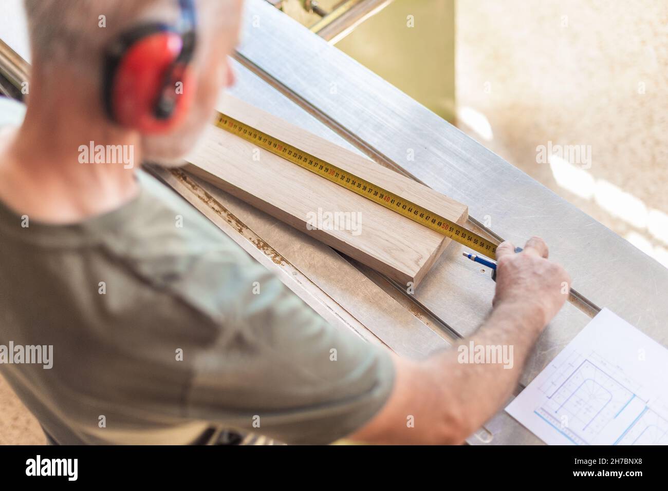 top view of a man measuring a board of wood Stock Photo - Alamy