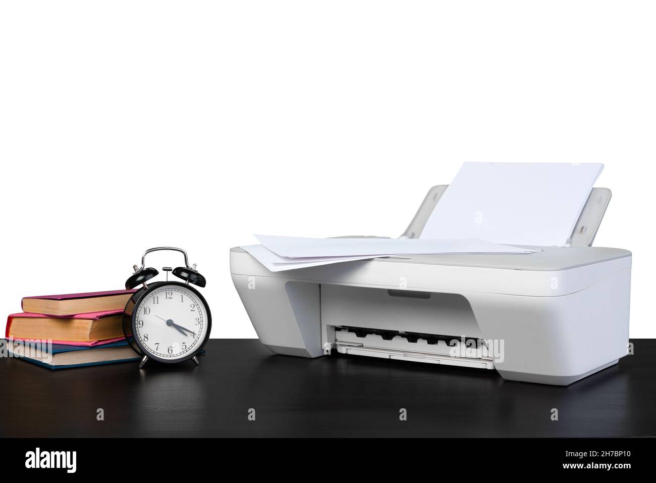 Printer and stack of books on black table against white background ...