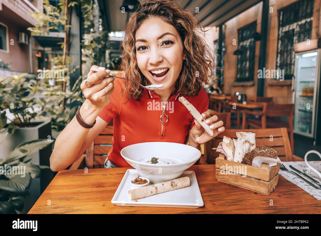 Happy cheerful woman eating lavash bread with traditional Armenian ...