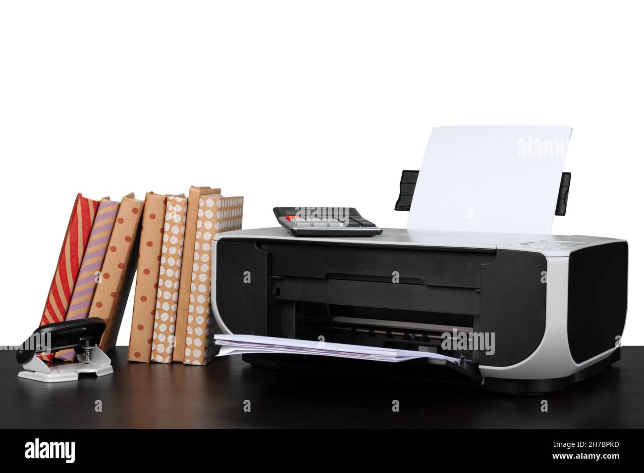 Printer and stack of books on black table against white background ...