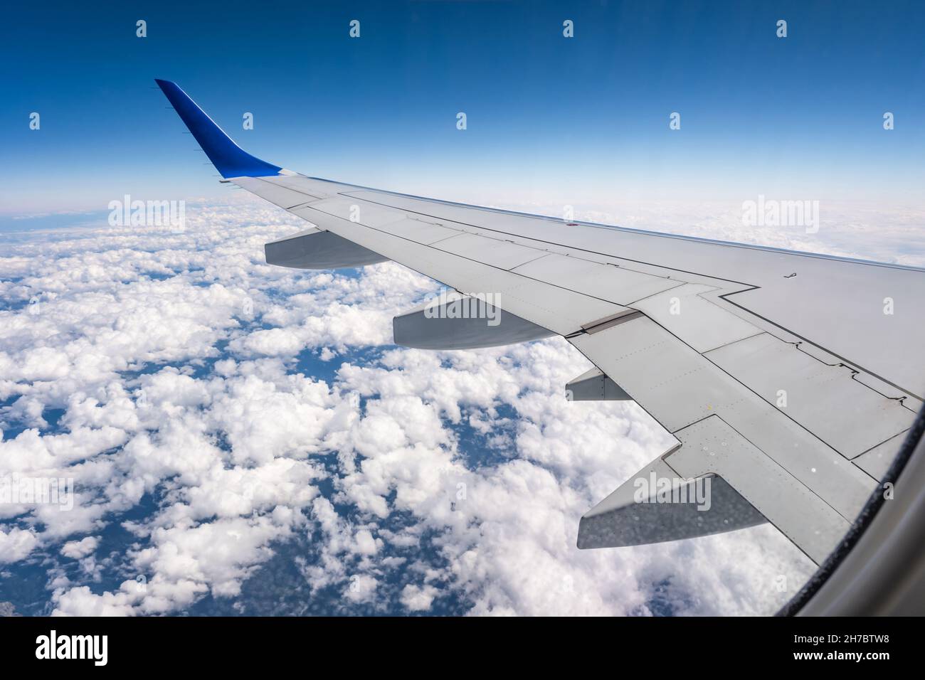 aircraft wing from the aircraft window overlooking the blue sky and ...