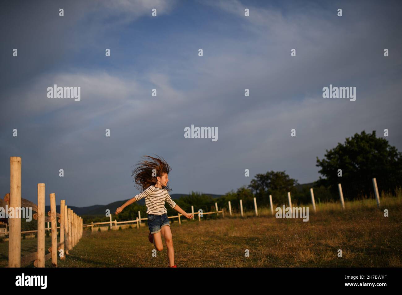 Happy little girl having fun and running outdoors in farm Stock Photo ...