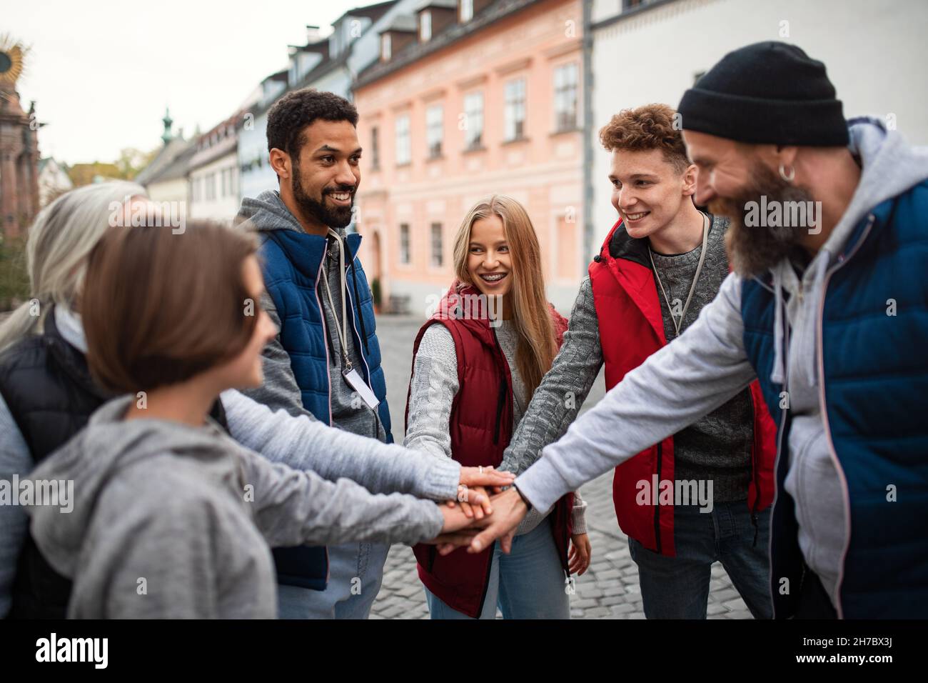 Diverse group of happy community service volunteers stacking hands ...