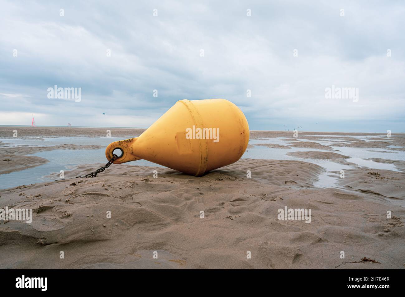 yellow buoy with rusty anchor chain at the beach of Berck sur mer in ...