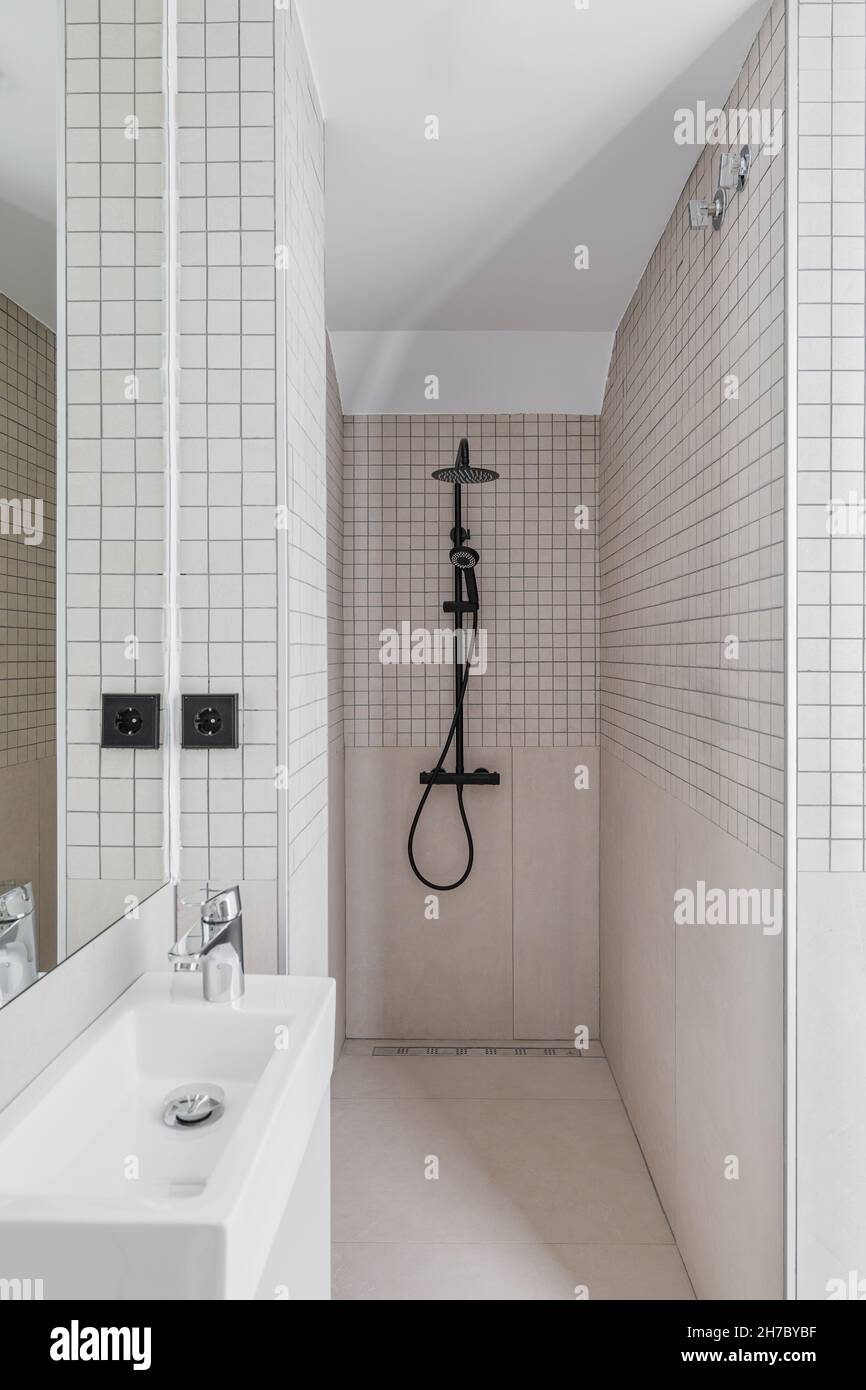 Narrow bathroom with shower zone and small sink. Interior of modern ...