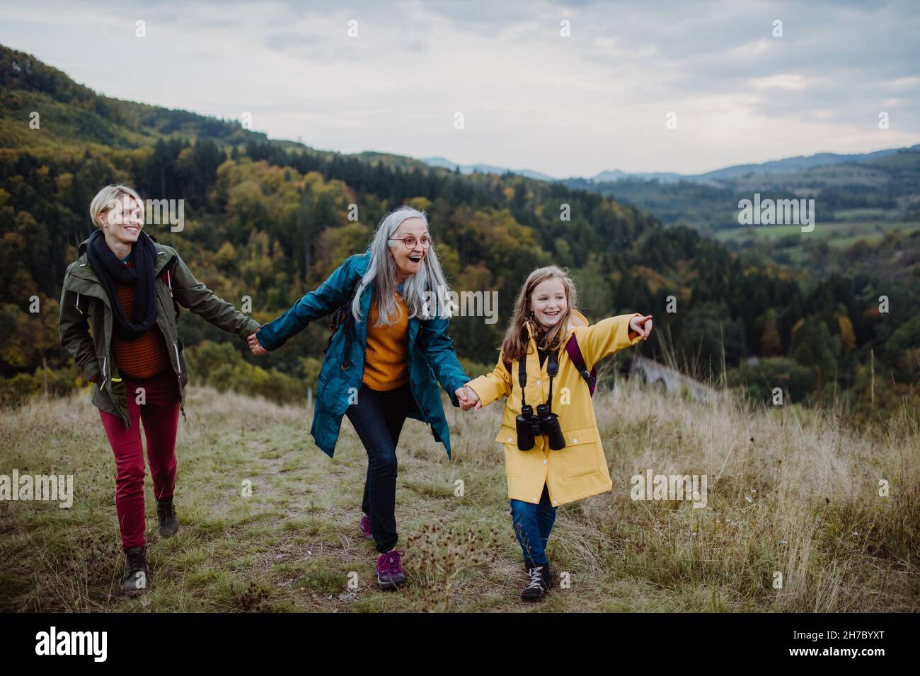 Small girl with mother and grandmother hiking outoors in nature Stock ...
