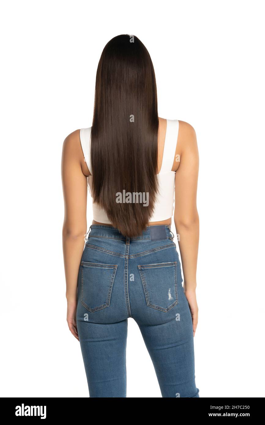 rear view of a young beautiful woman with long hair and jeans on a ...