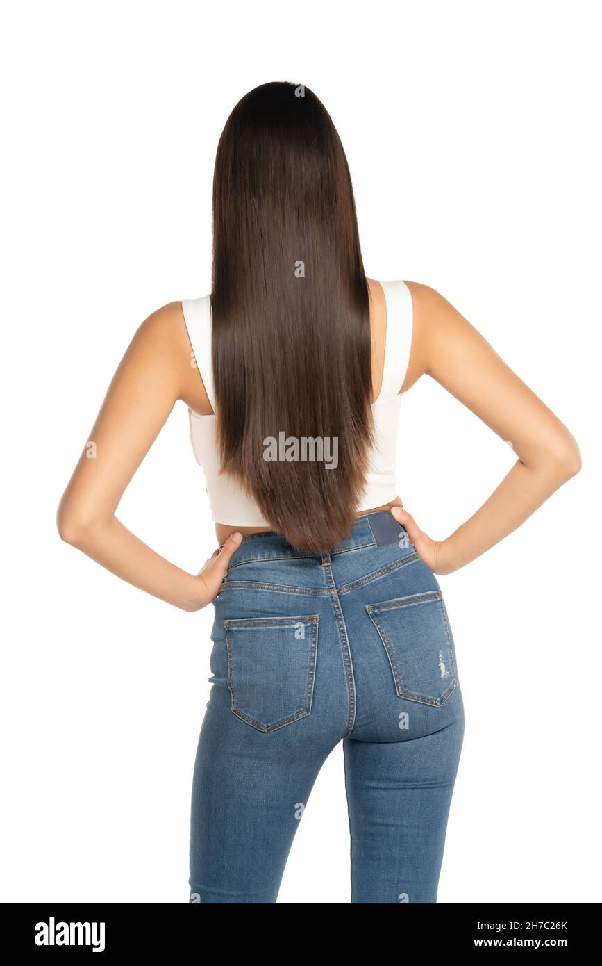 rear view of a young beautiful woman with long hair and jeans on a ...