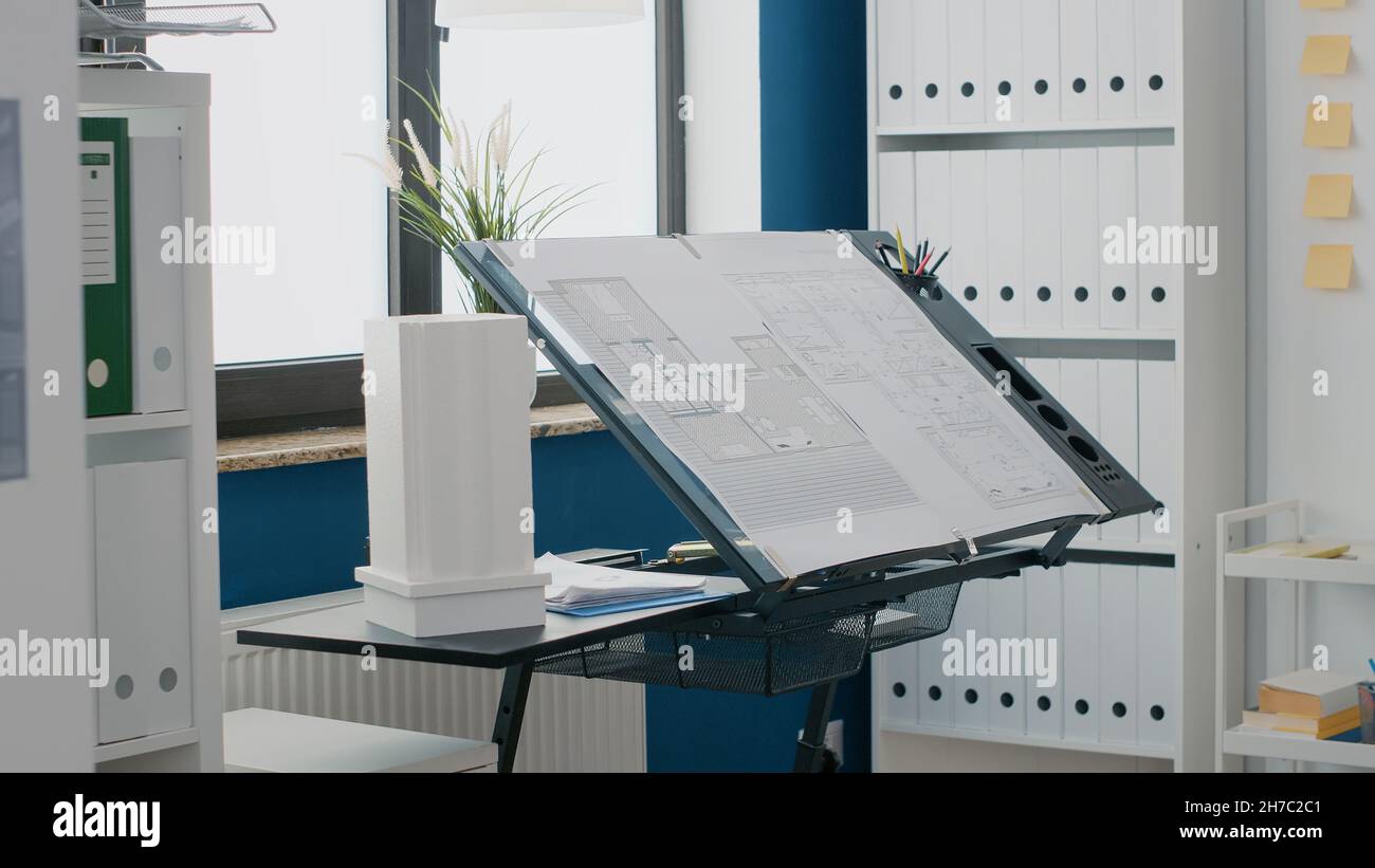Close up of blueprints plan and building model on table in empty space ...