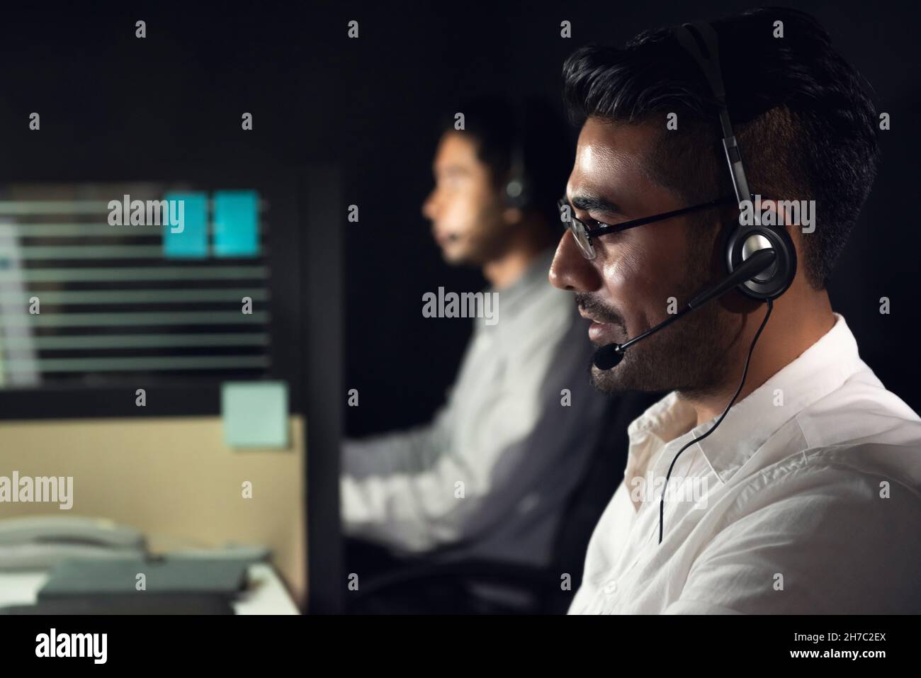 Asian business man working night shift in call center office with ...