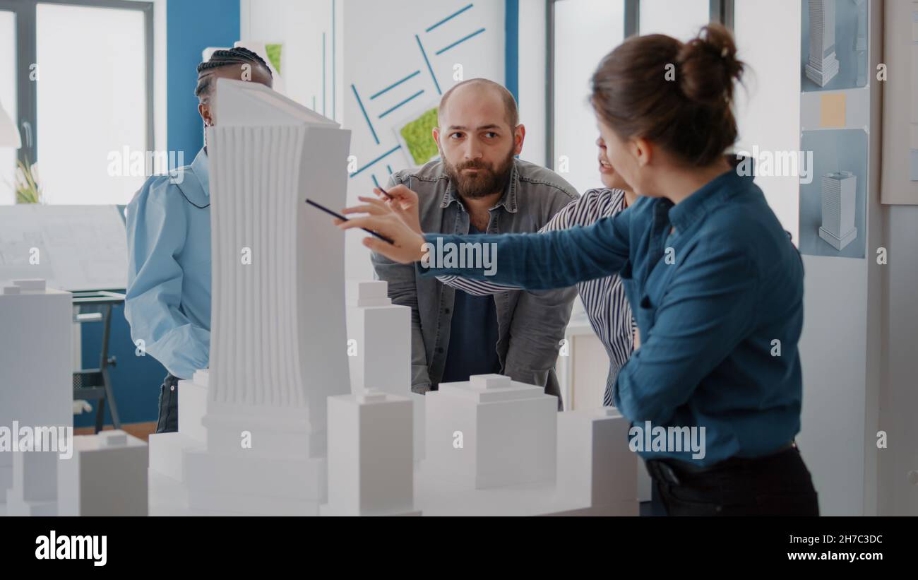 Man Meeting With Women To Discuss About Building Model And To Plan Project Strategy In Office