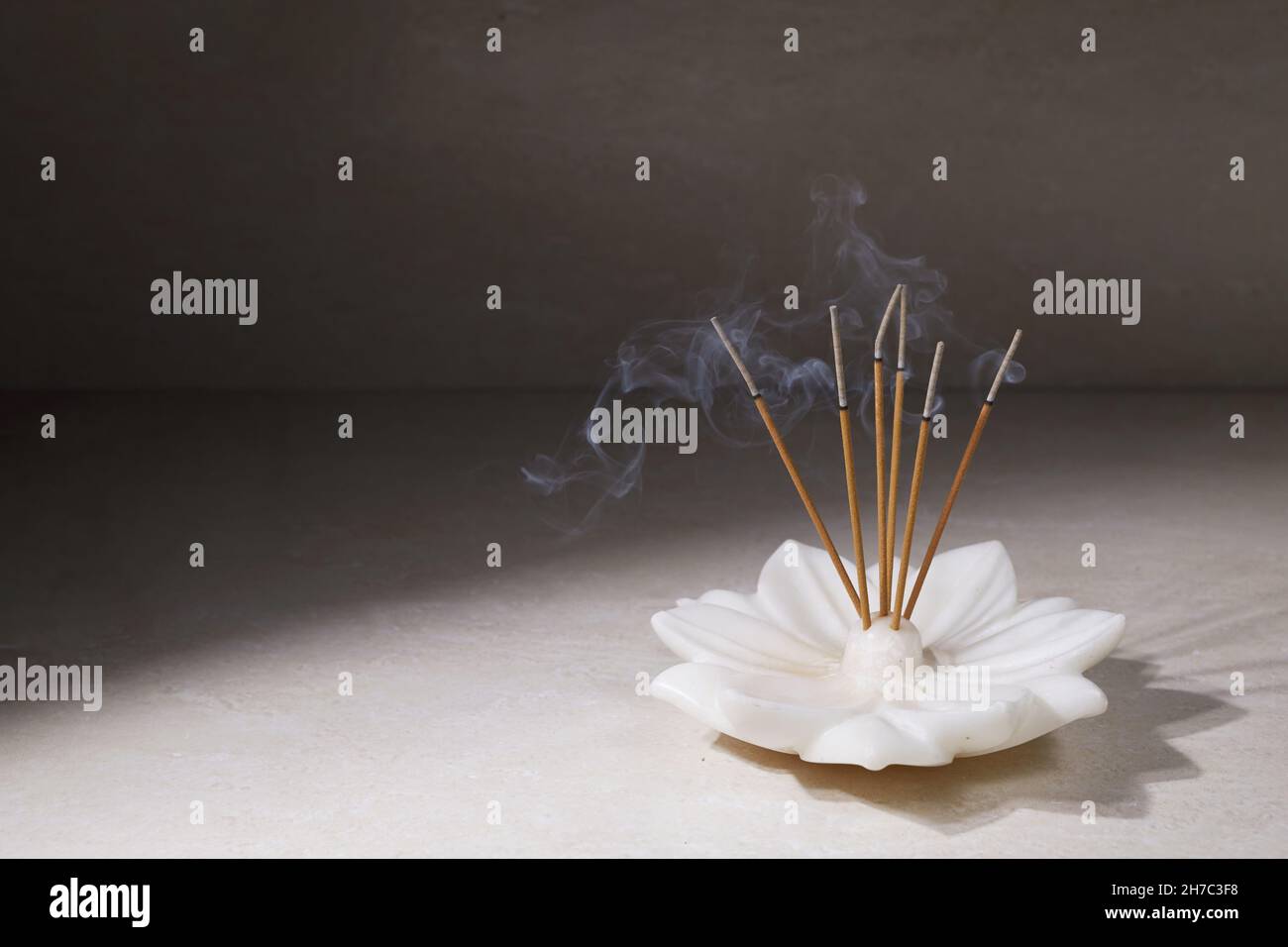 Smoke from burning incense sticks standing on lotus incense holder ...