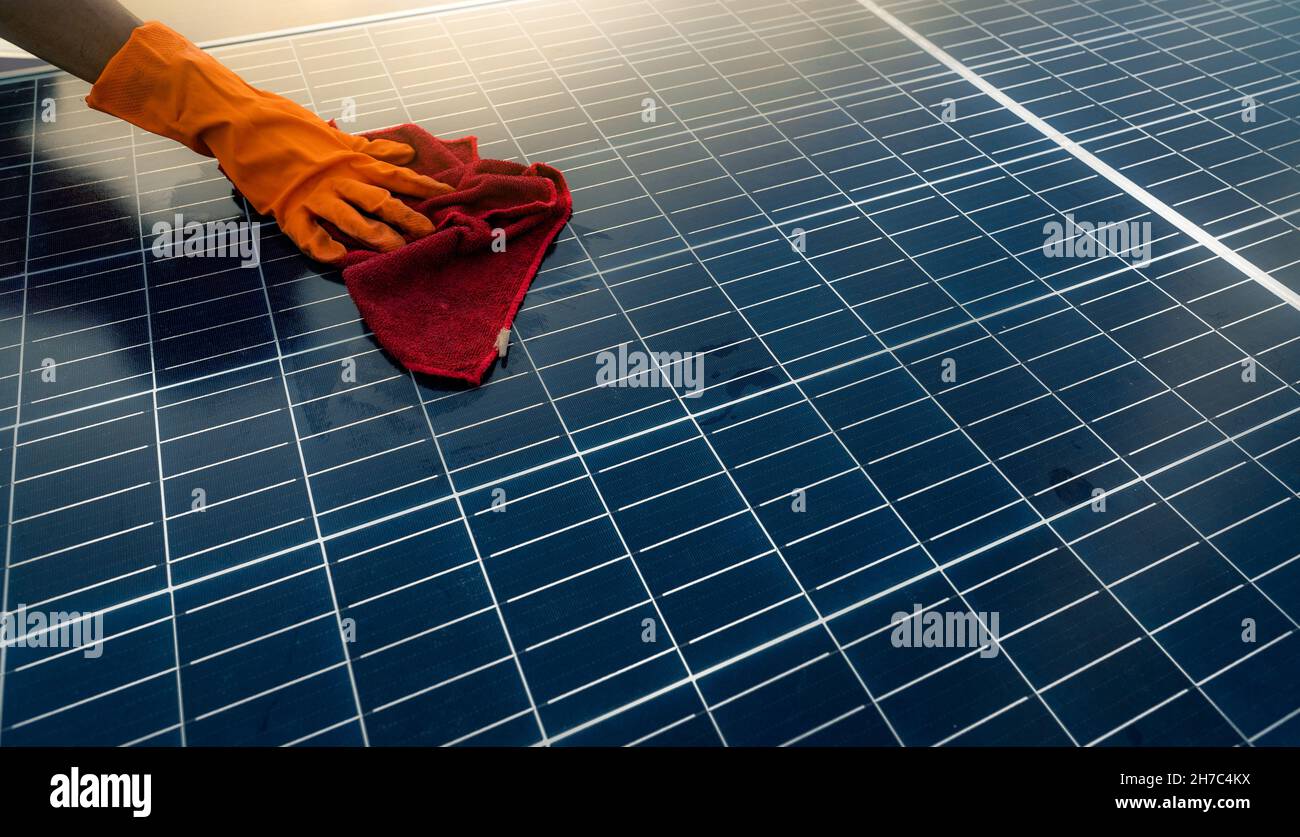 Man cleaning solar panel on roof. Solar panel or photovoltaic module ...