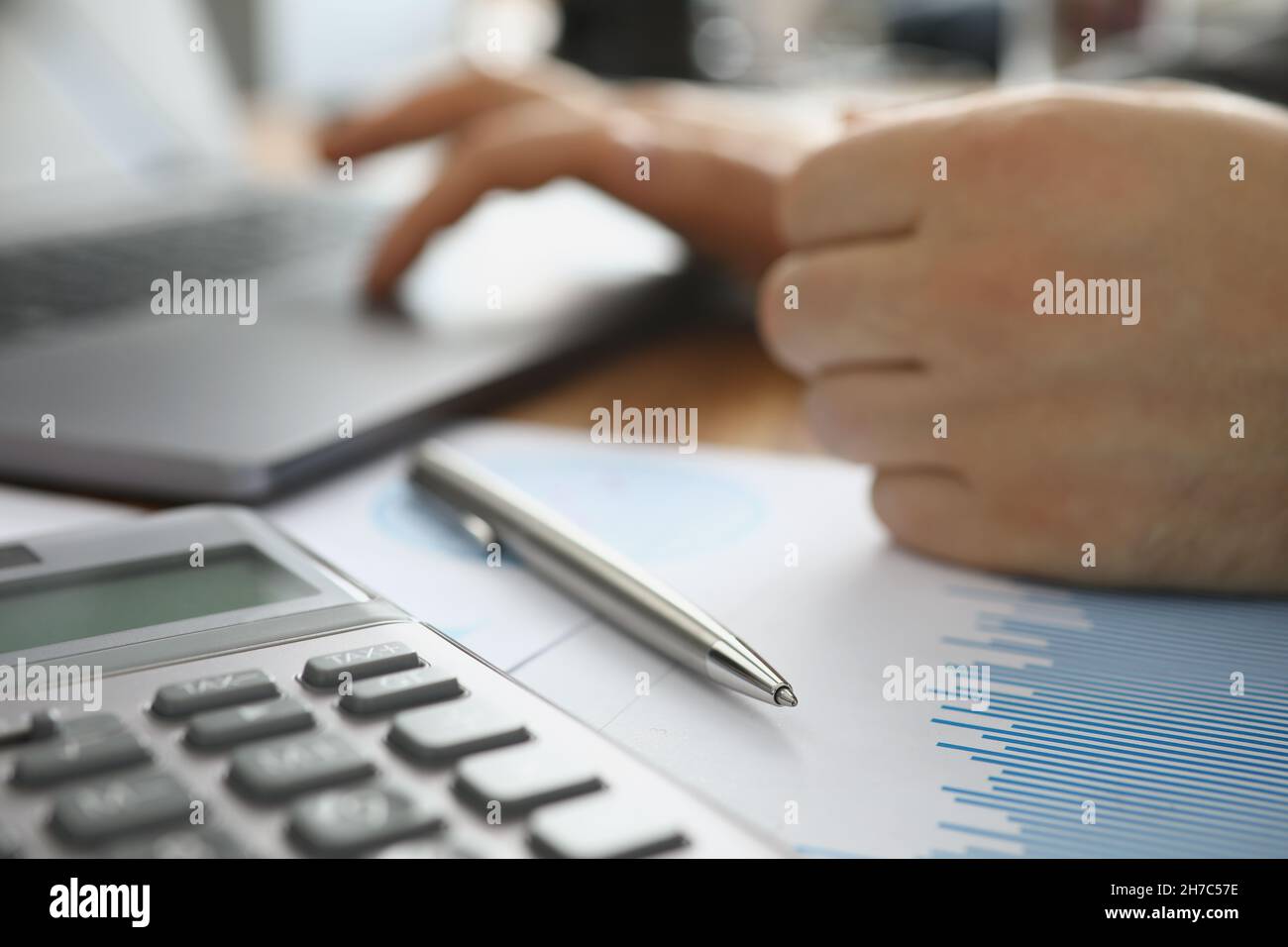 Person typing on laptop and calculating numbers in office Stock Photo ...