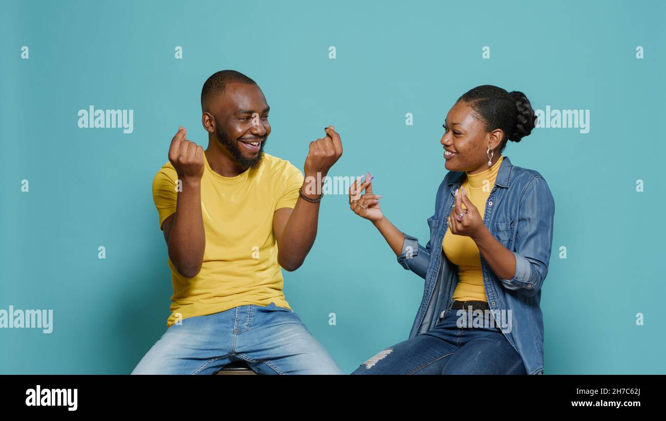 People using body language to do money gesture with hands in studio ...
