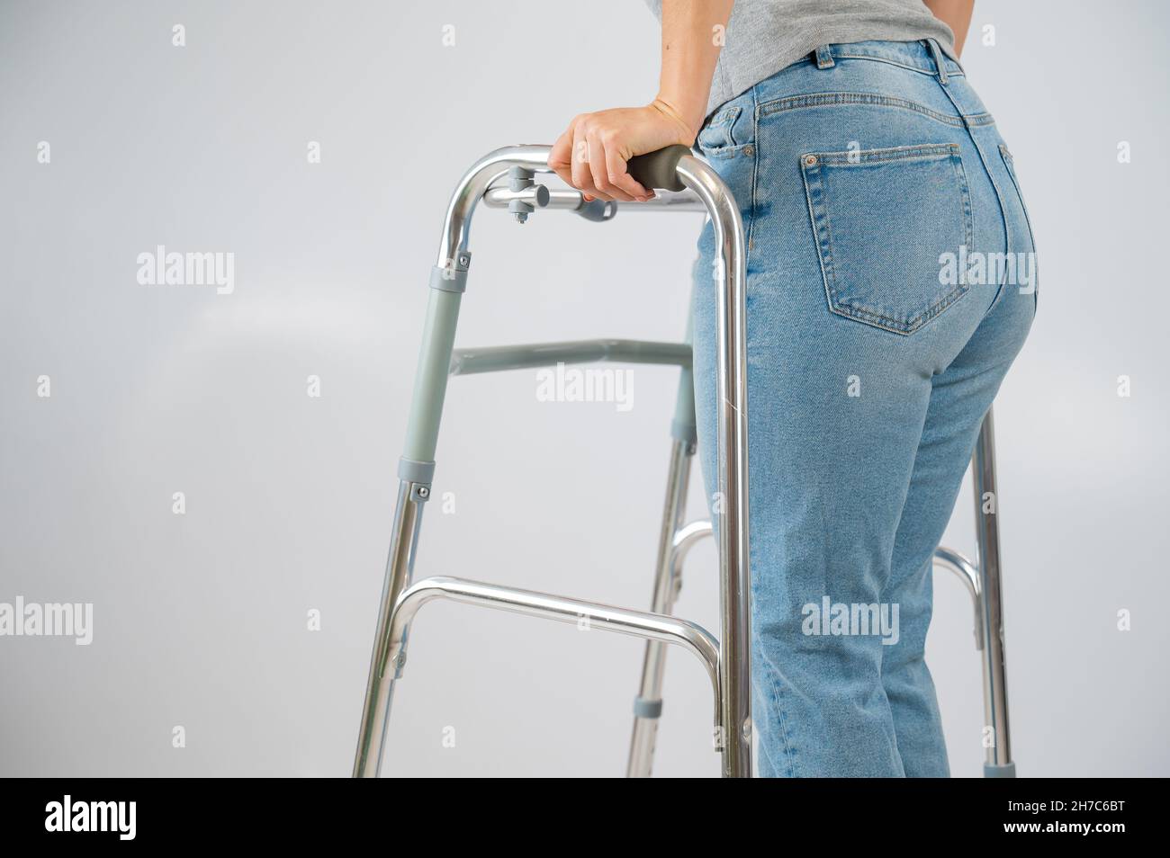 A woman is walking with a walker on a white background Stock Photo - Alamy