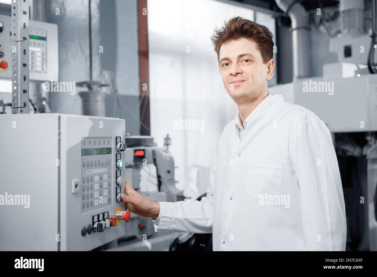 Male operator engineer controls production line from control panel ...