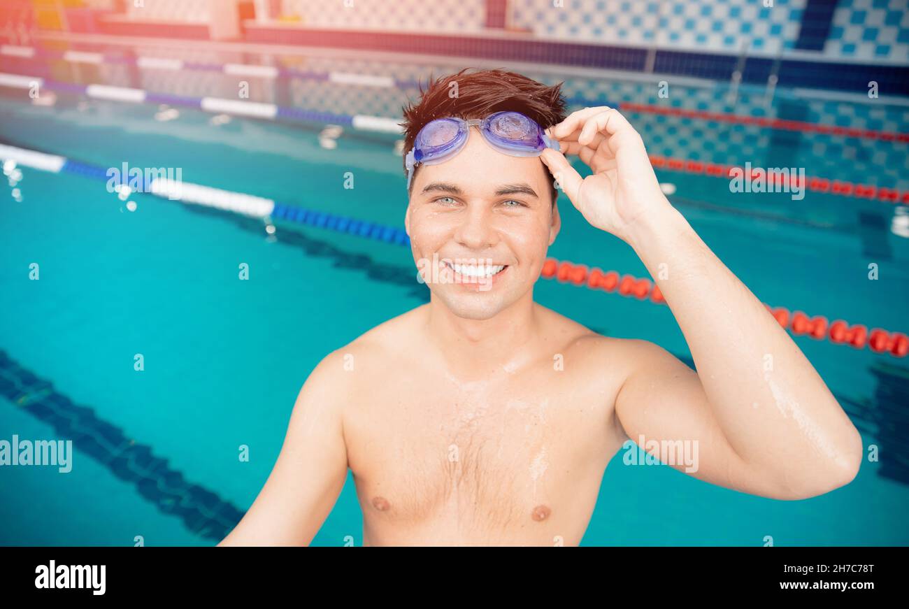 Portrait swimmer happy young man, background swimming pool blue water ...