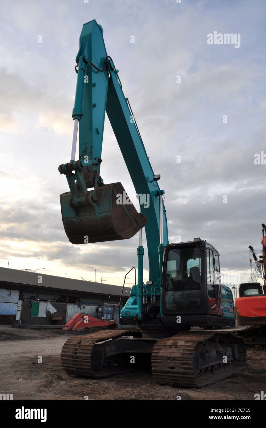 The green excavator vehicle after use and is parked by the port Stock ...