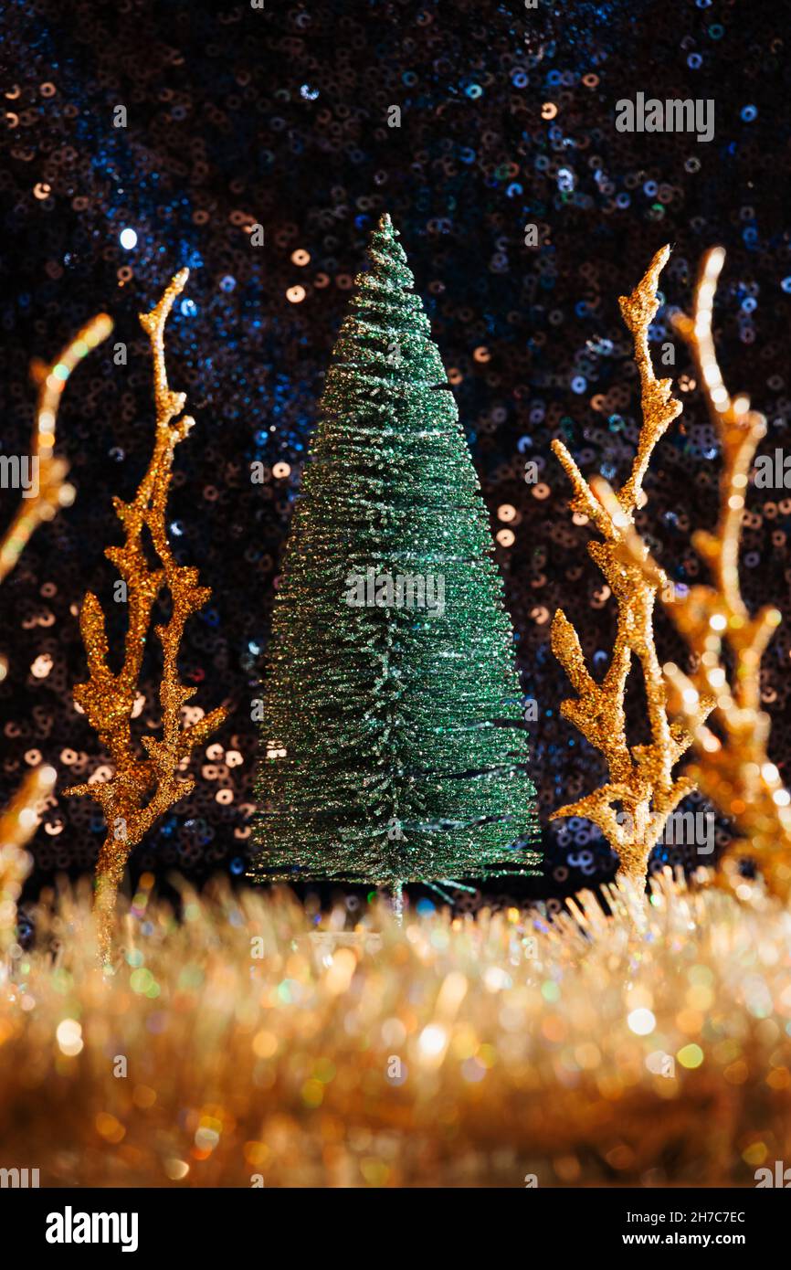 green glitter mini Christmas tree on blue sequin background as a starry ...