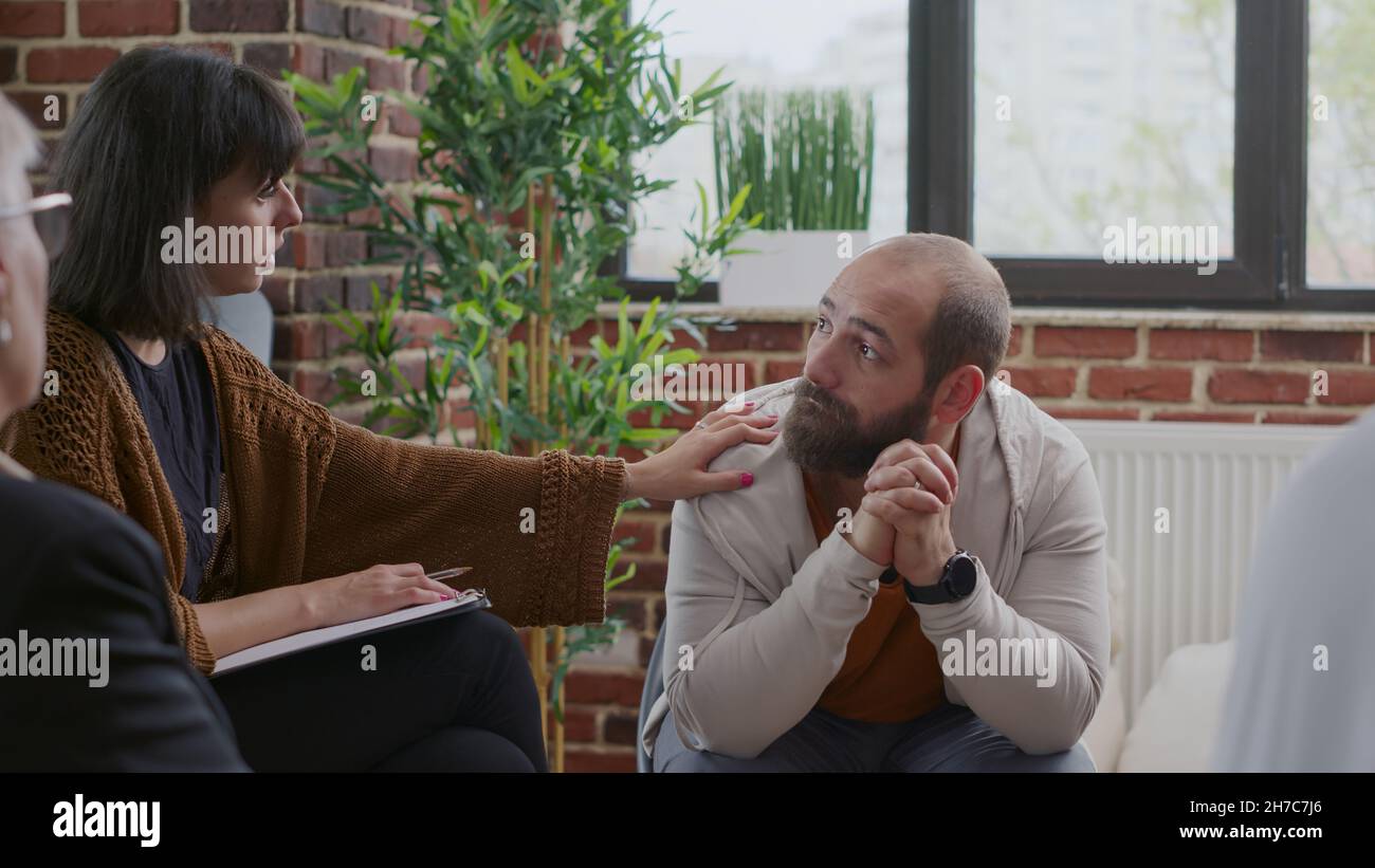 Close up of man trembling and shaking at aa group therapy session with ...