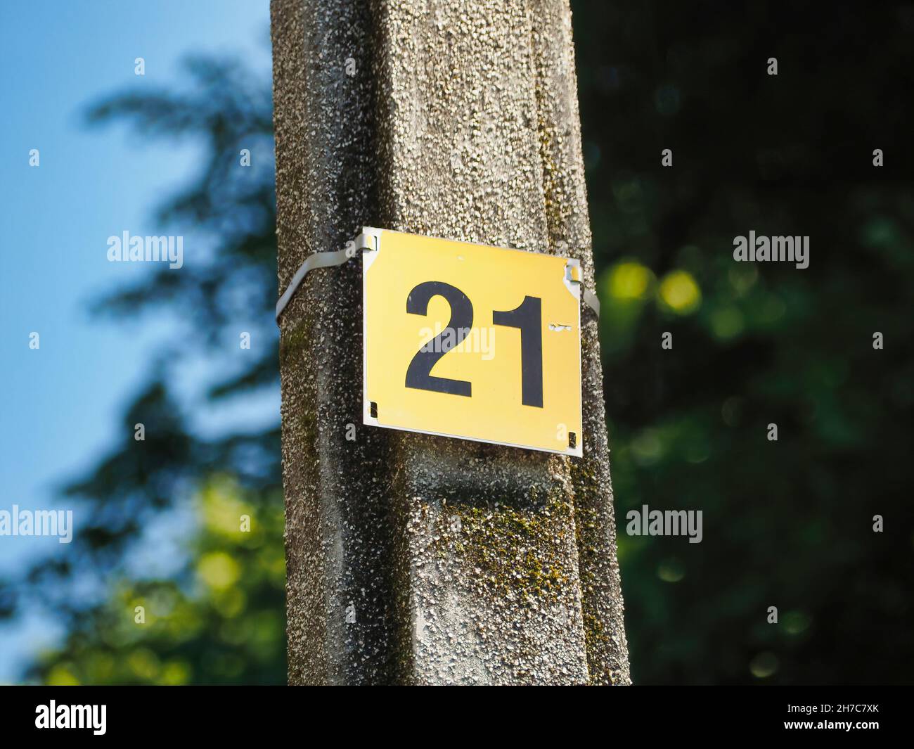 Selective focus shot of sign with numbers twenty-one on a pole outside ...