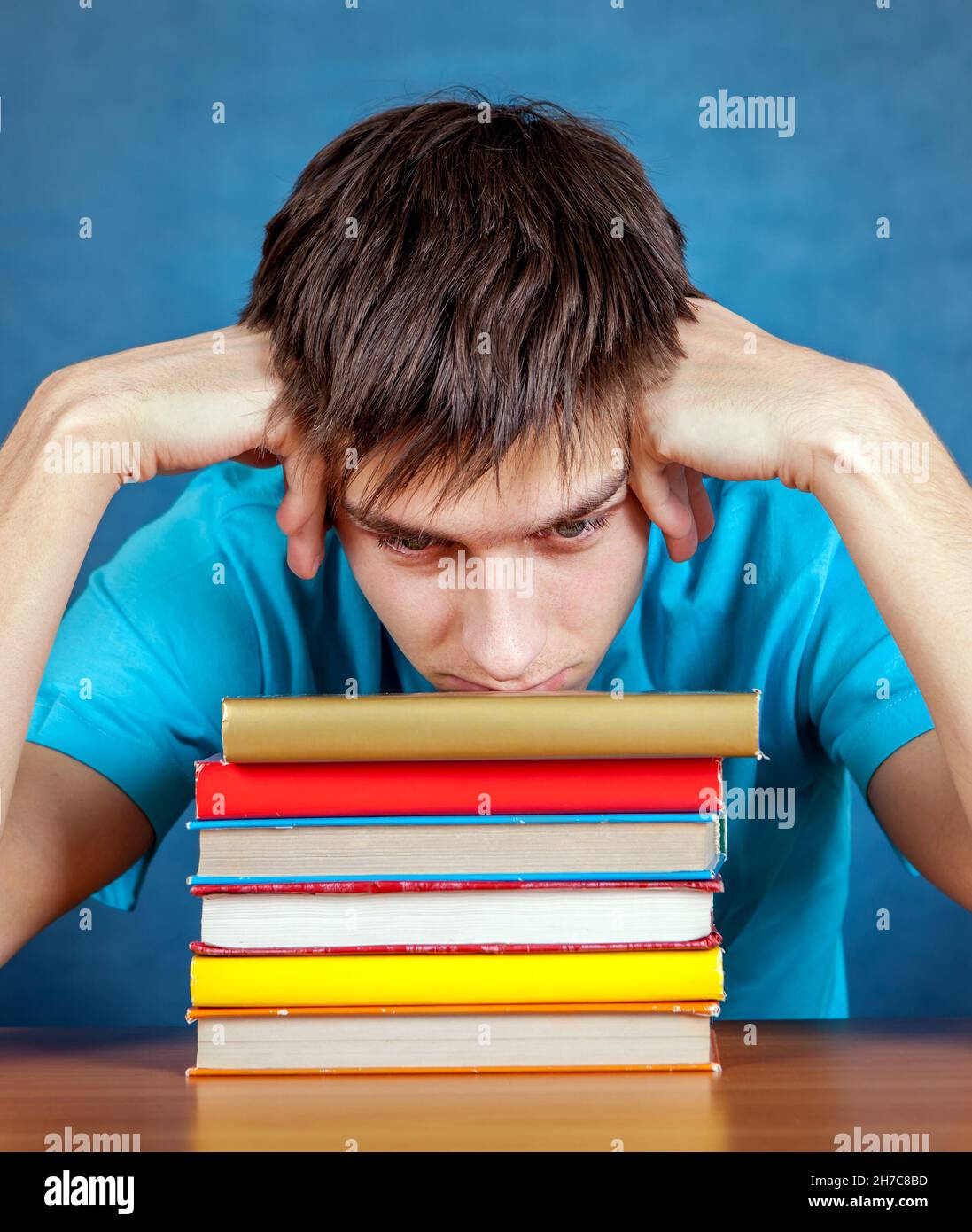 Tired Student with the Book on the Blue Background Stock Photo - Alamy