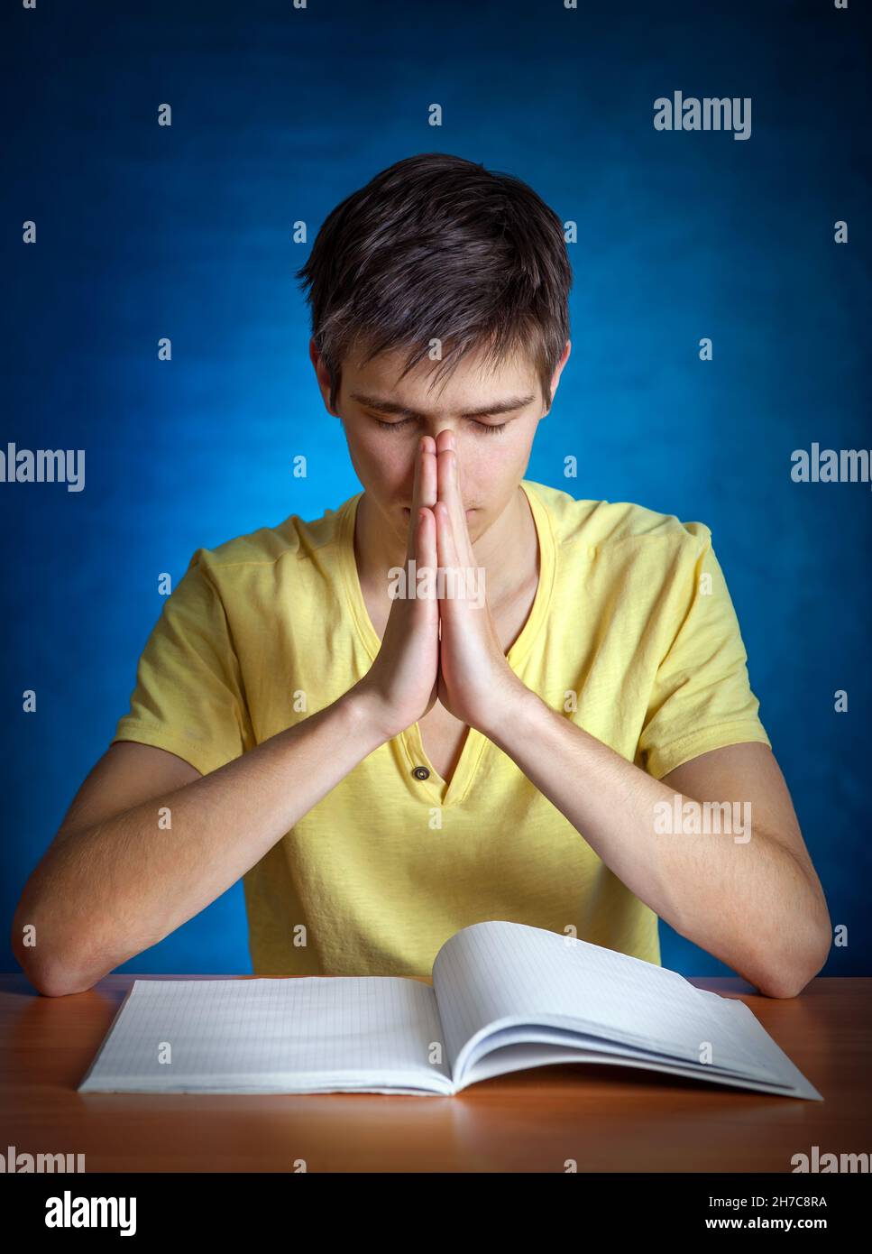 Young Man praying on the Blue Background Stock Photo - Alamy