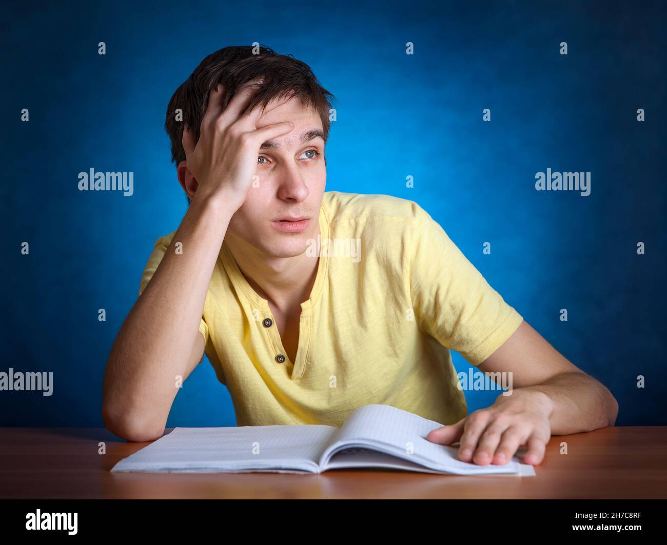 Sad and Stressed Student at the School Desk on the Blue Background ...