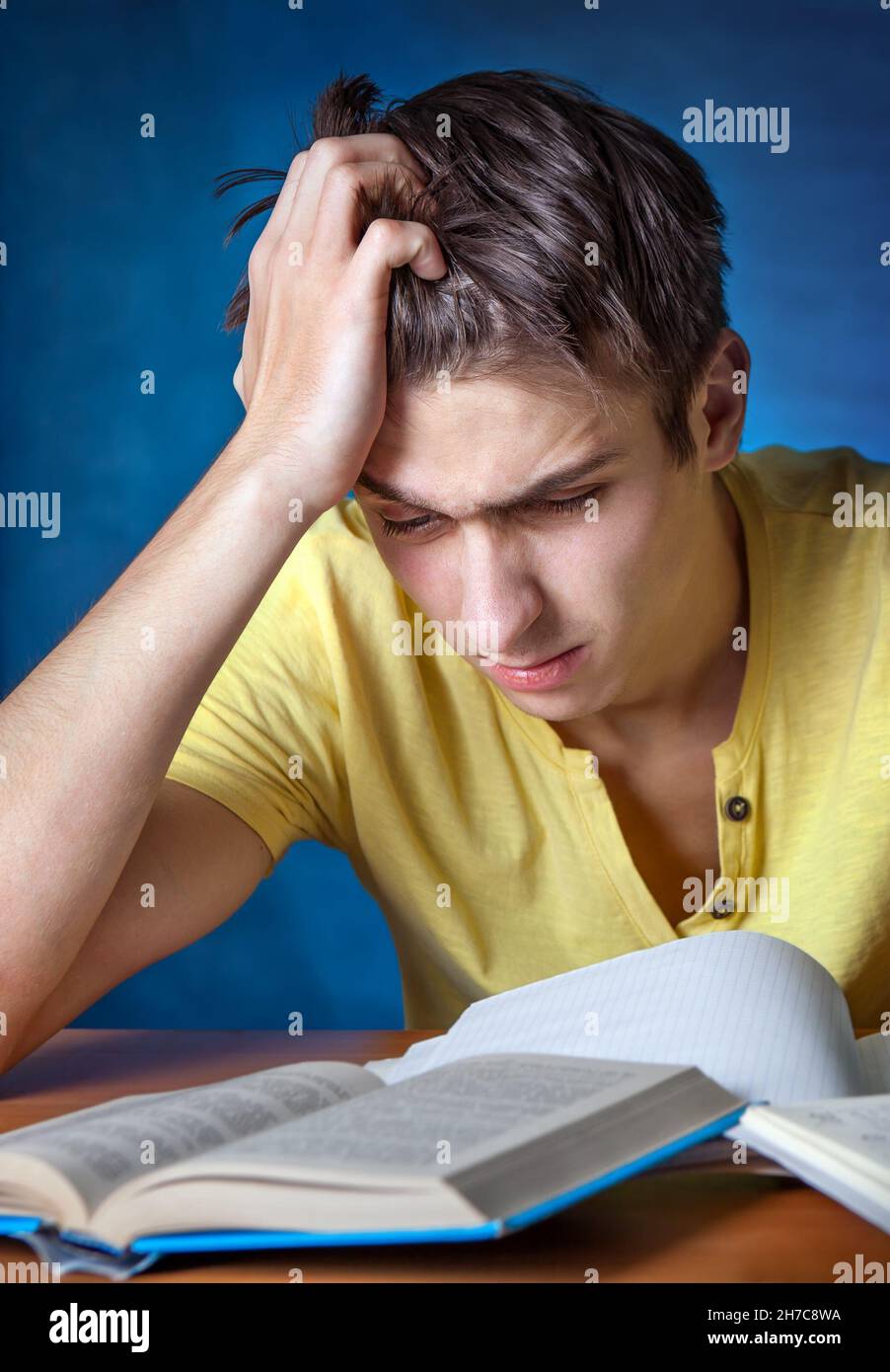 Sad and Stressed Student at the School Desk on the Blue Background ...
